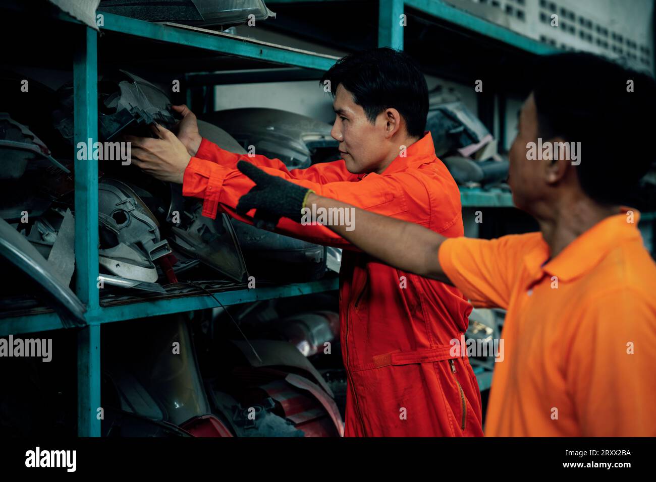 Mechanic worker inspect spare vehicle parts stored in inventory at ... Mechanic worker inspect spare vehicle parts stored in inventory at ...