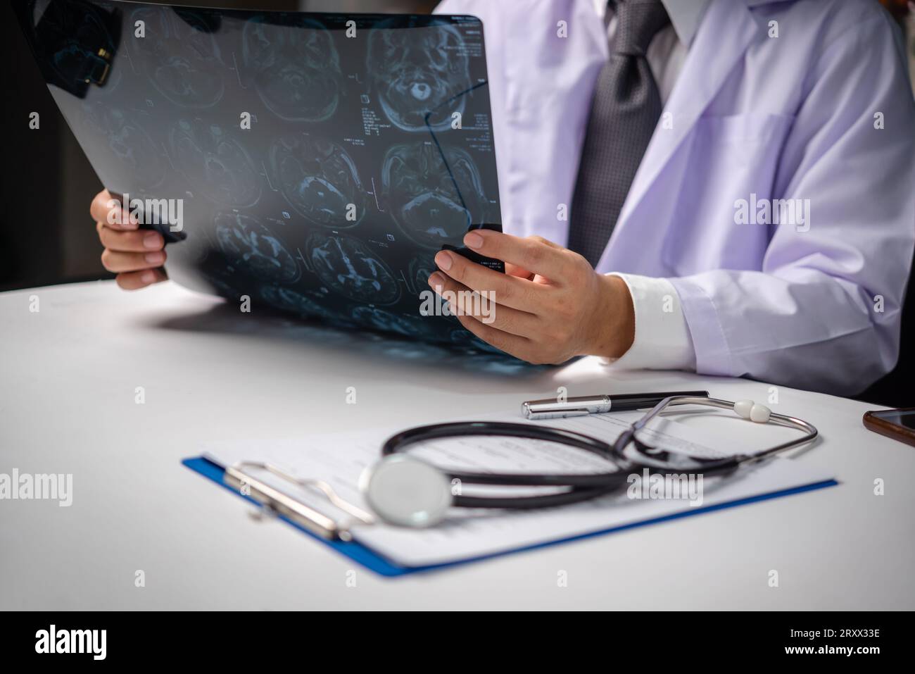 Doctor holding x-ray film before surgery. MRI and CT scan examining at diagnosing patient’s ...