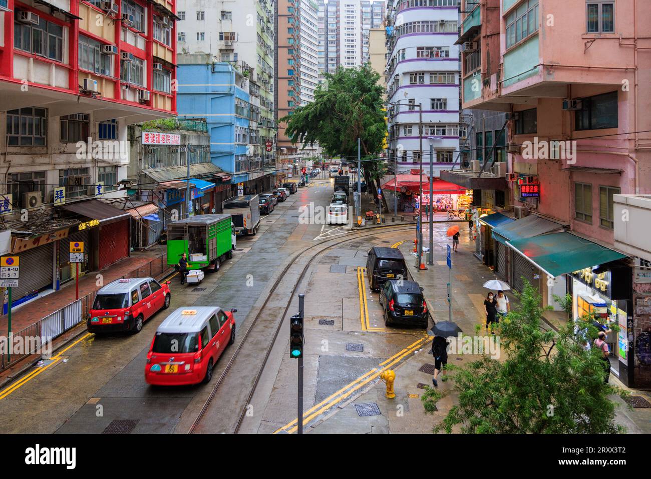 Hong Kong - September 5, 2023: Taxis and people walk on wet streets ...