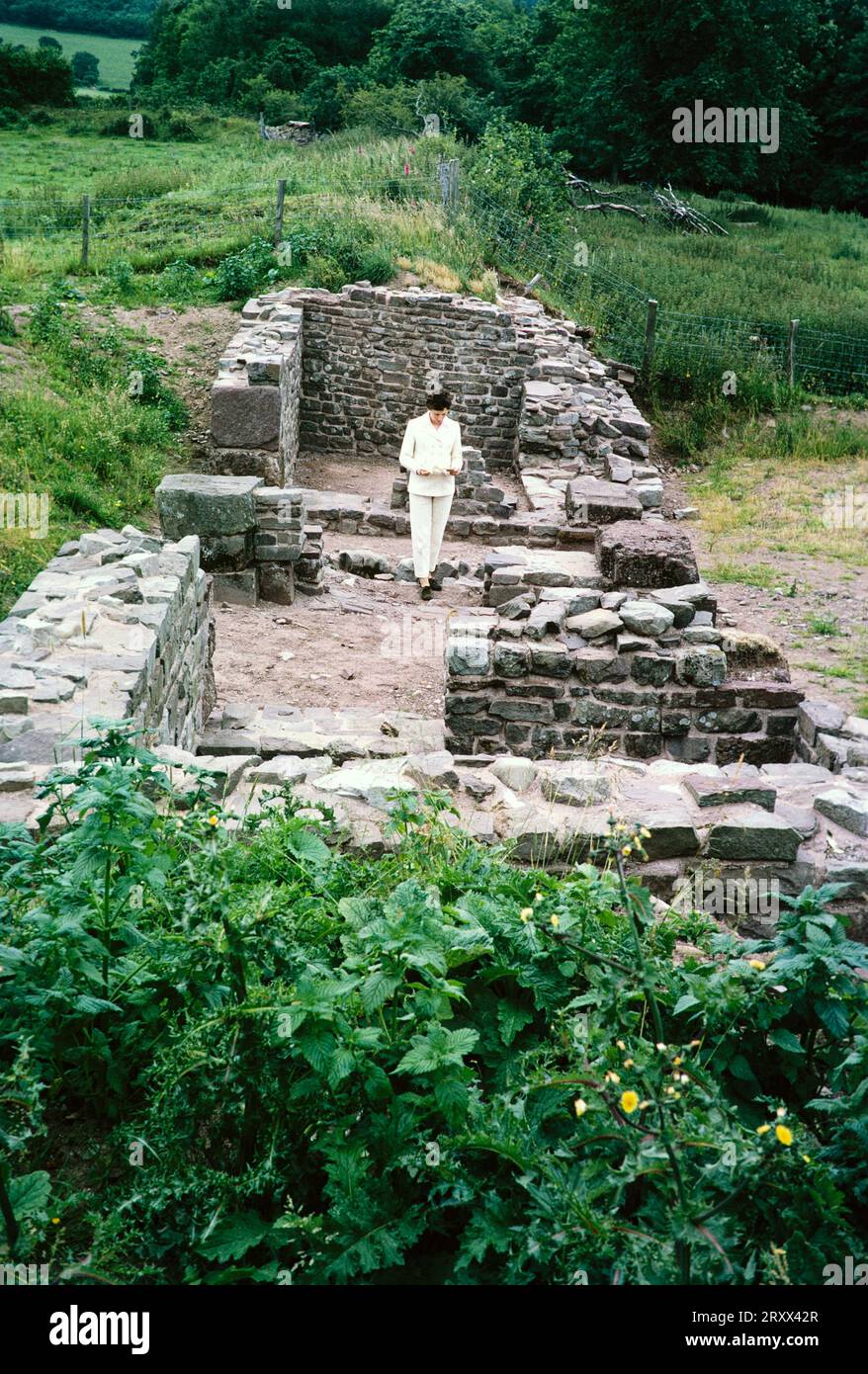 Woman standing in Y Gaer south gatehouse of the Roman fort, AD75-AD140 ...