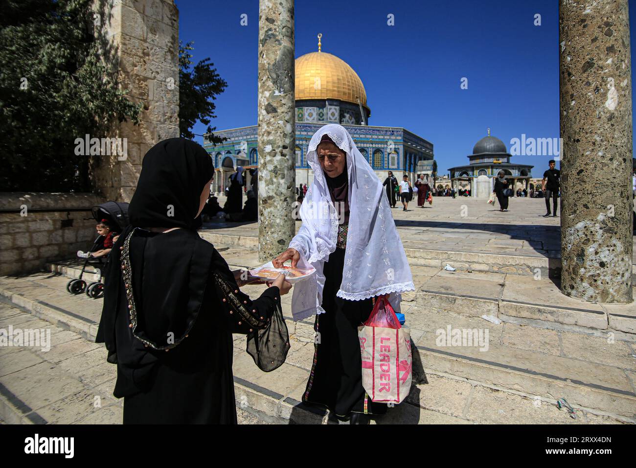 A Palestinian girl gives some snacks to an elderly lady during the ...