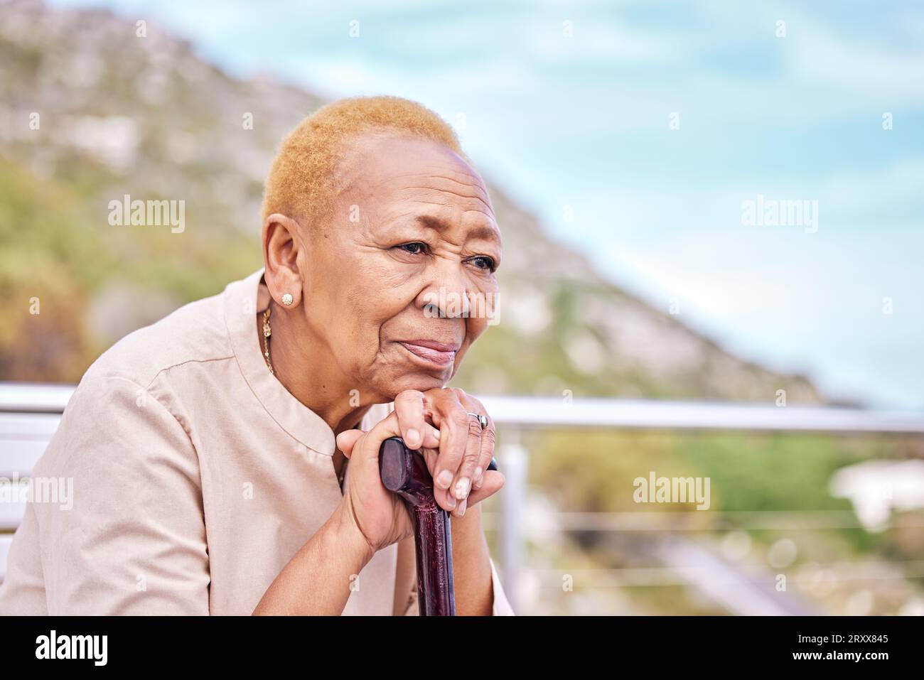 Depression, walking stick and a sad elderly woman on a park bench with ...