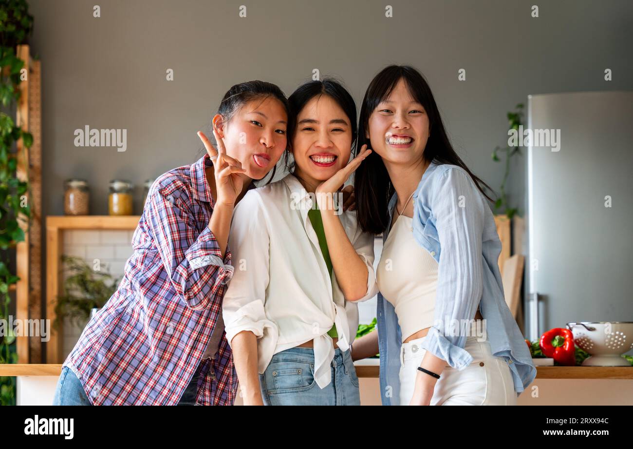 Happy beautiful chinese women friends bonding at home - Playful pretty ...