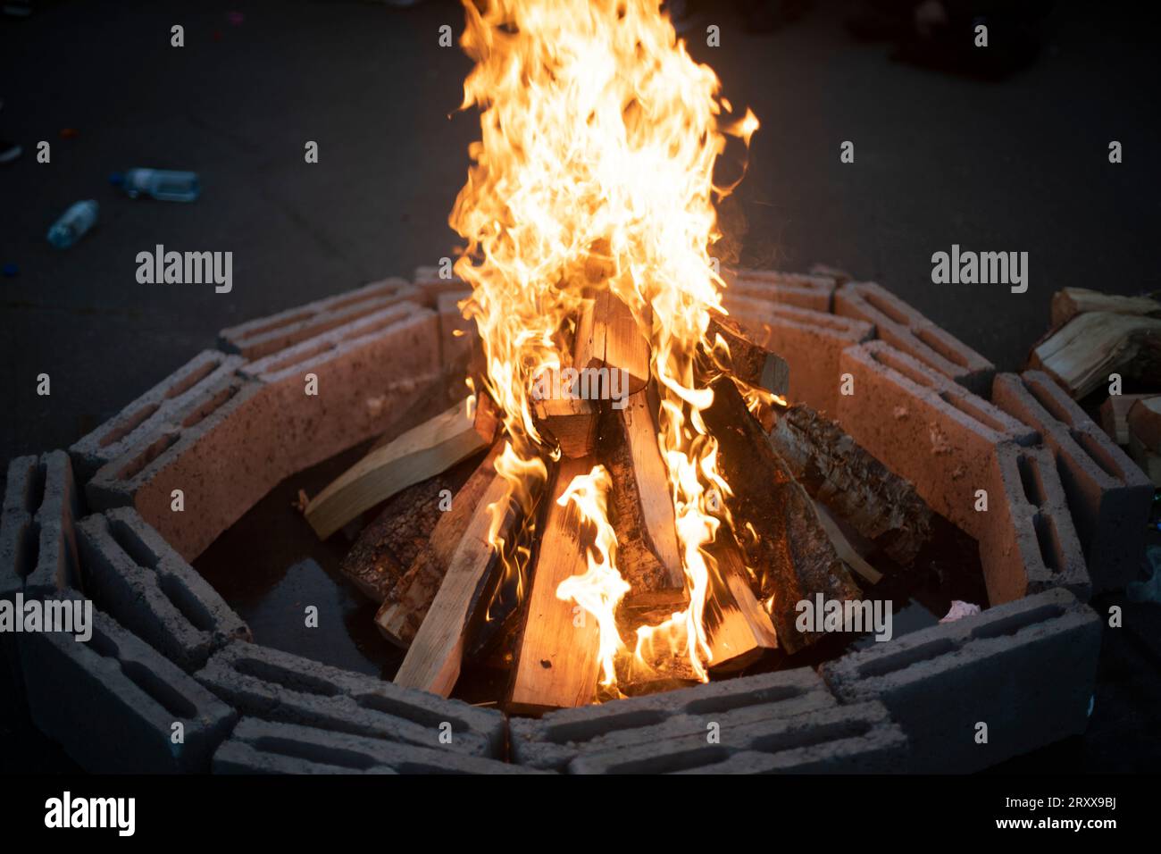 Large bonfire on street. Bonfire in evening. Concrete blocks around ...