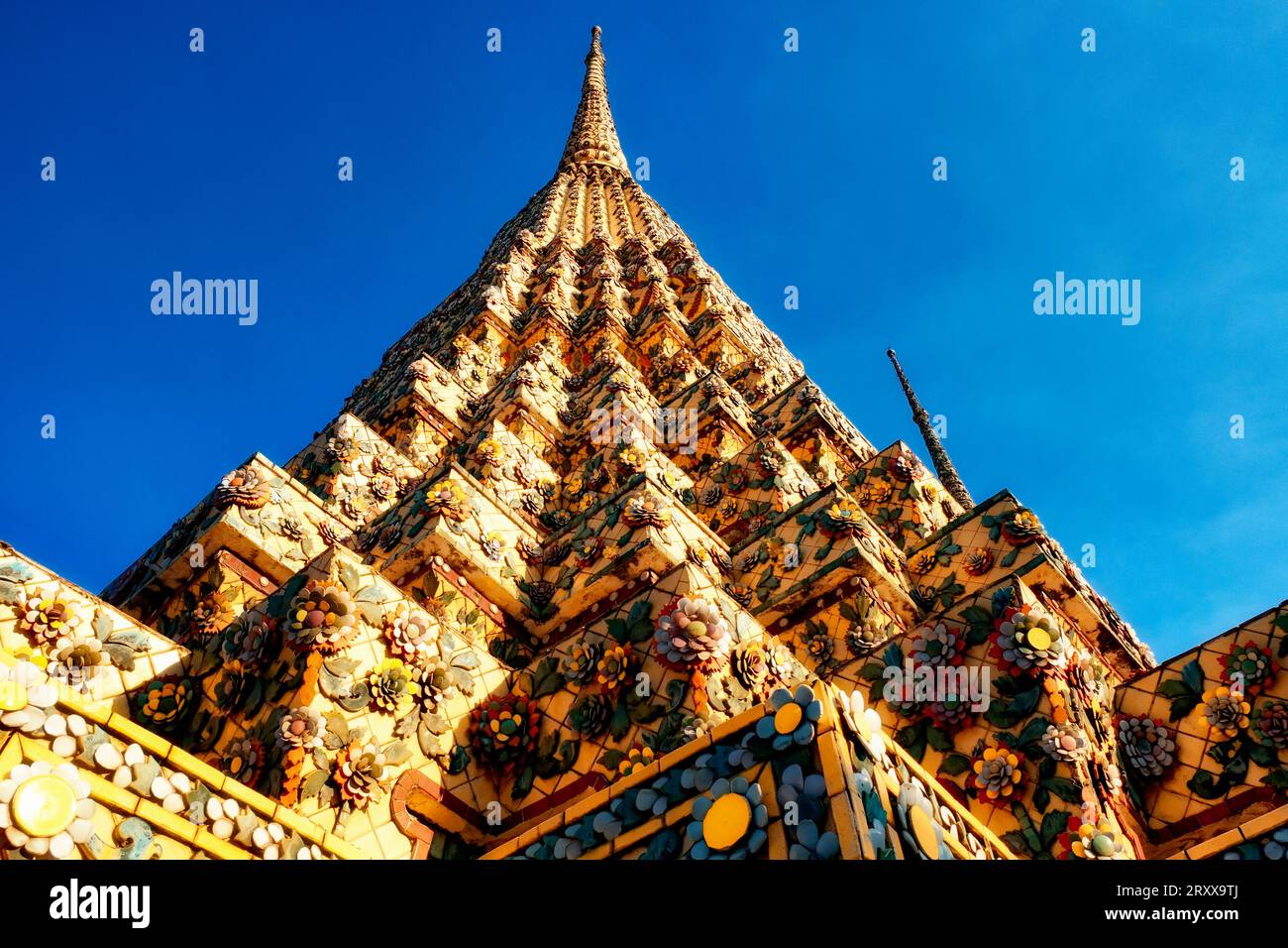 The picture conveys ornate temple spires in Thailand, garlanded with ...