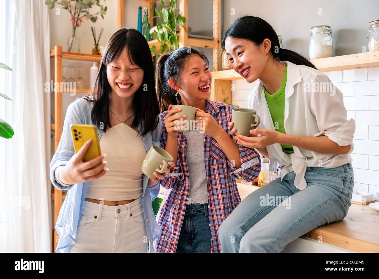 Happy beautiful chinese women friends bonding at home - Playful pretty ...