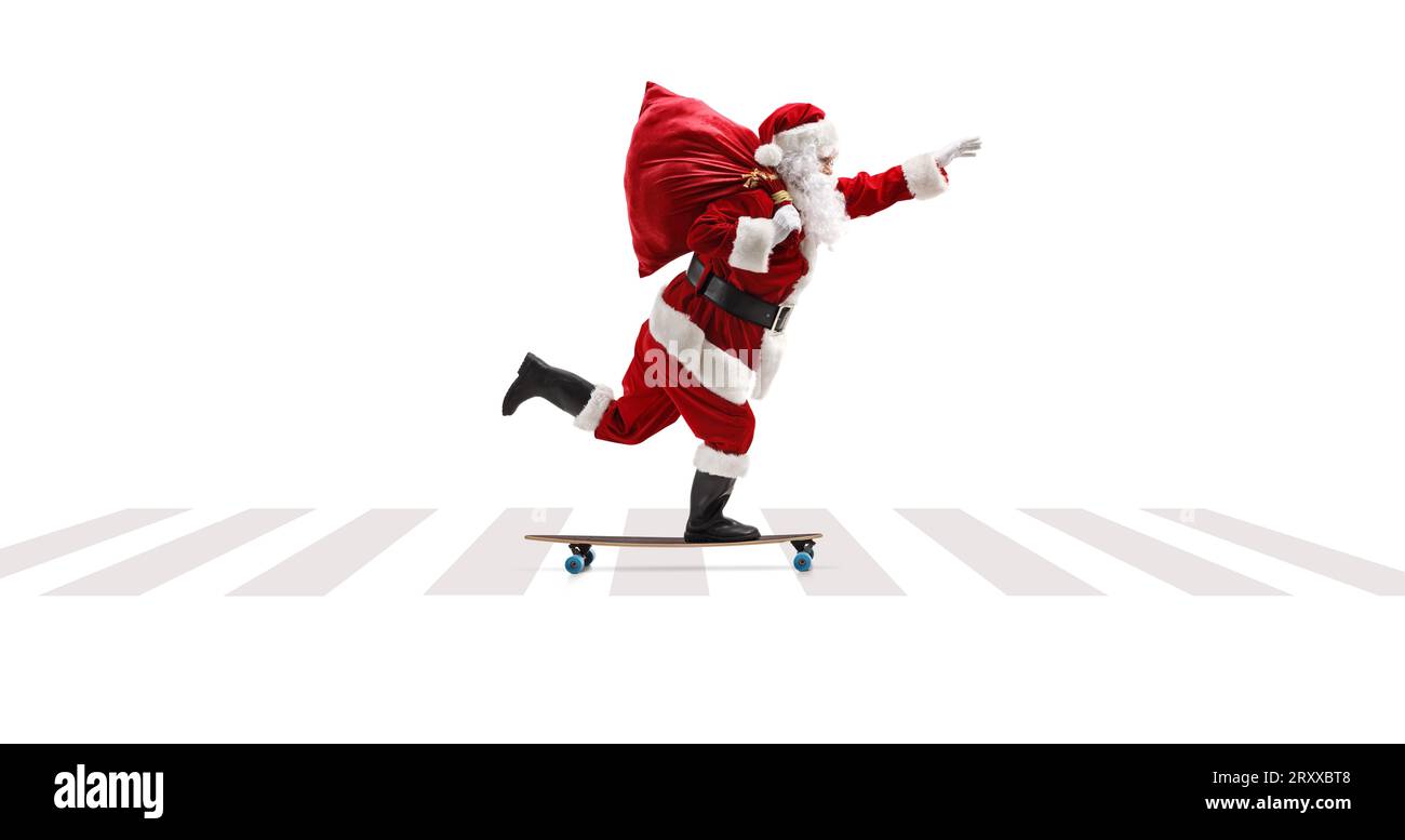 Full length profile shot of Santa Claus riding a longboard at a ...