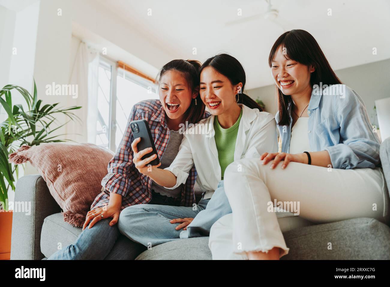 Happy beautiful chinese women friends bonding at home - Playful pretty ...