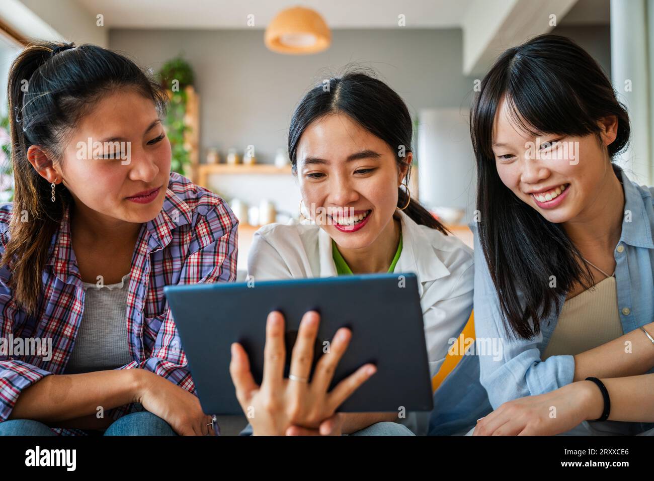 Happy beautiful chinese women friends bonding at home - Playful pretty ...