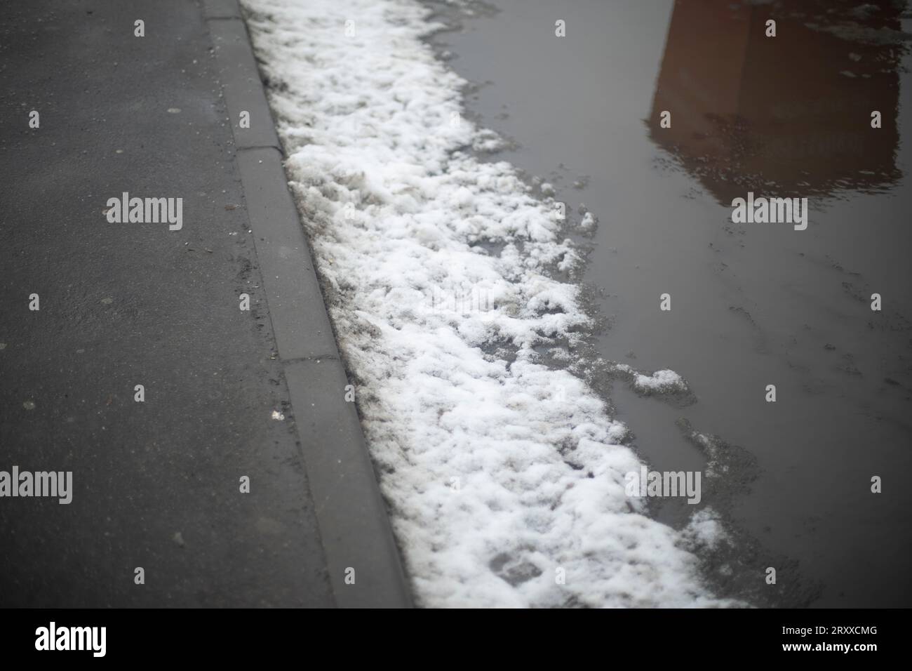 Melted snow on road. Large puddle in spring. Lots of water on asphalt ...