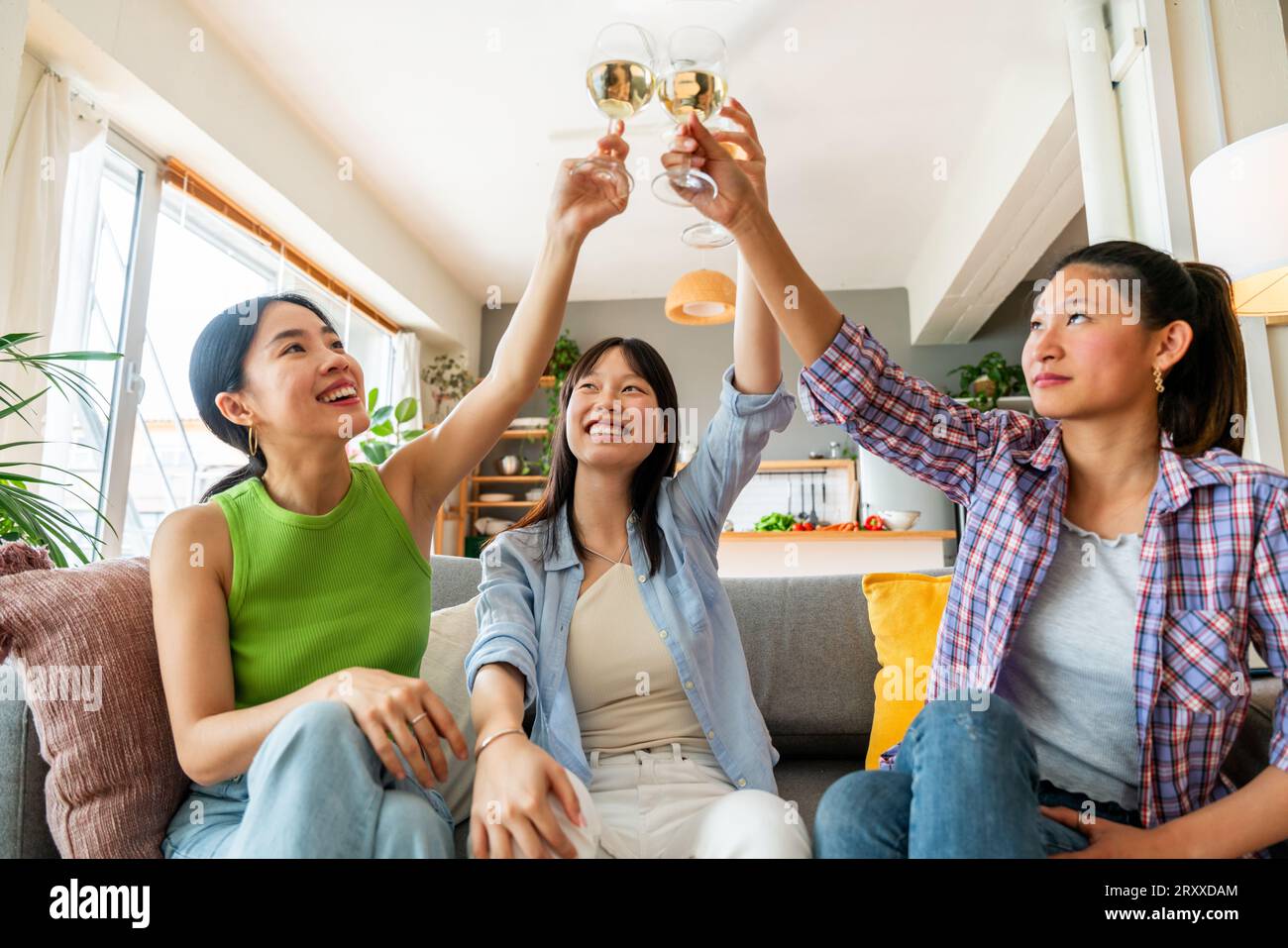 Happy beautiful chinese women friends bonding at home - Playful pretty ...
