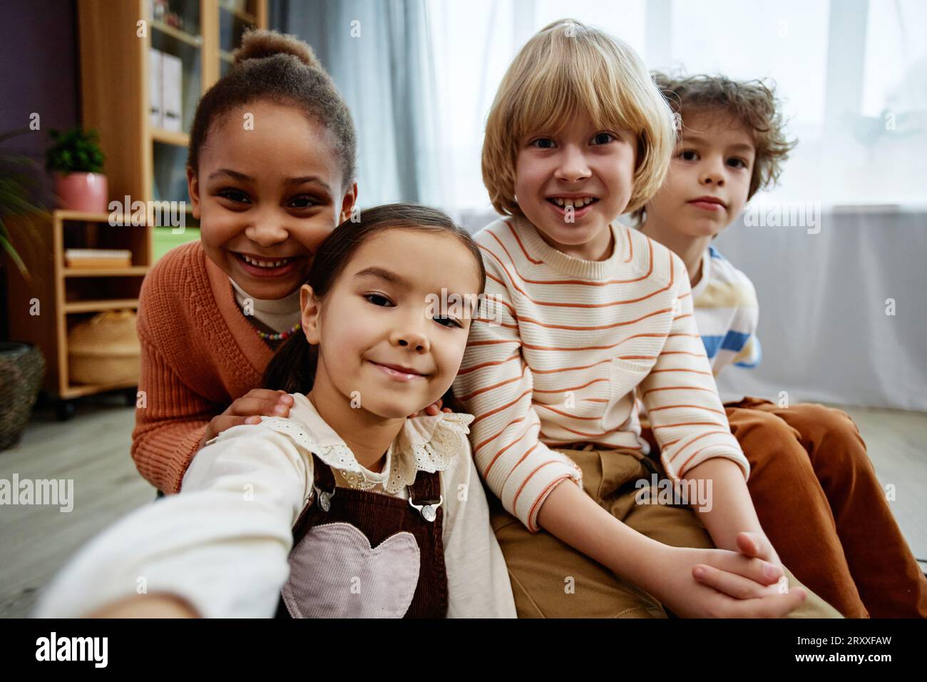 Diverse group of little children taking selfie photo and smiling at ...