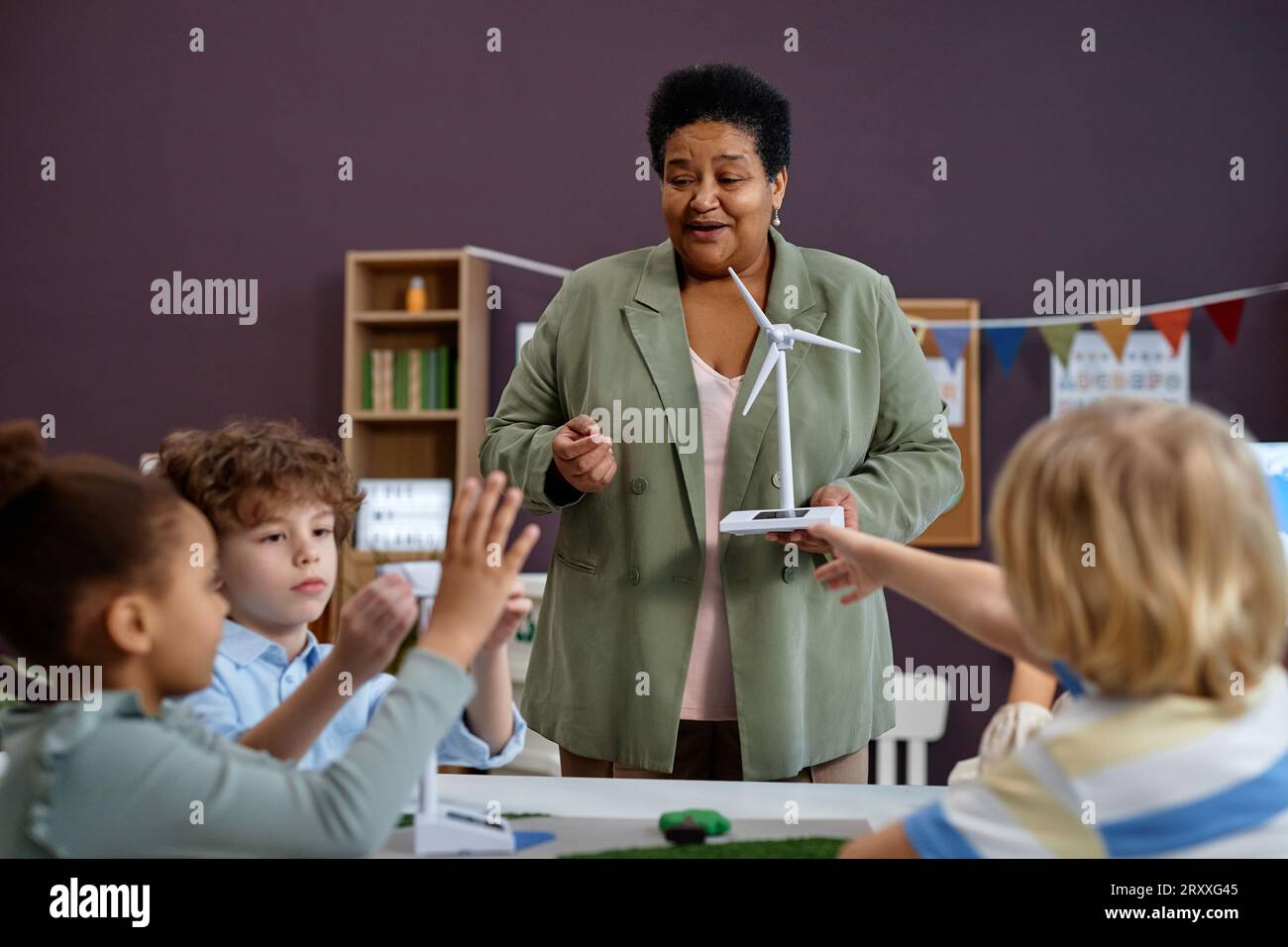 Waist up portrait of Black woman holding wind turbine model teaching ...