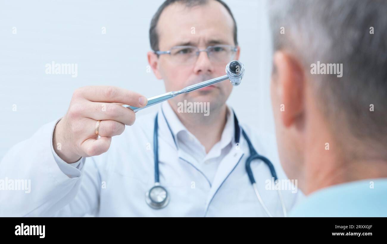 A neurologist examines the nervous system and reflexes of a male ...
