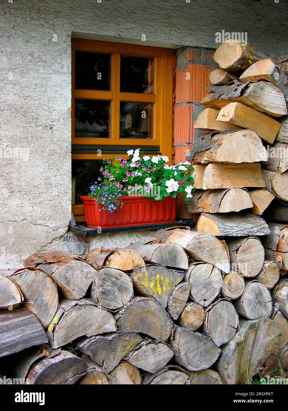 Window with flowers, wood pile Stock Photo - Alamy
