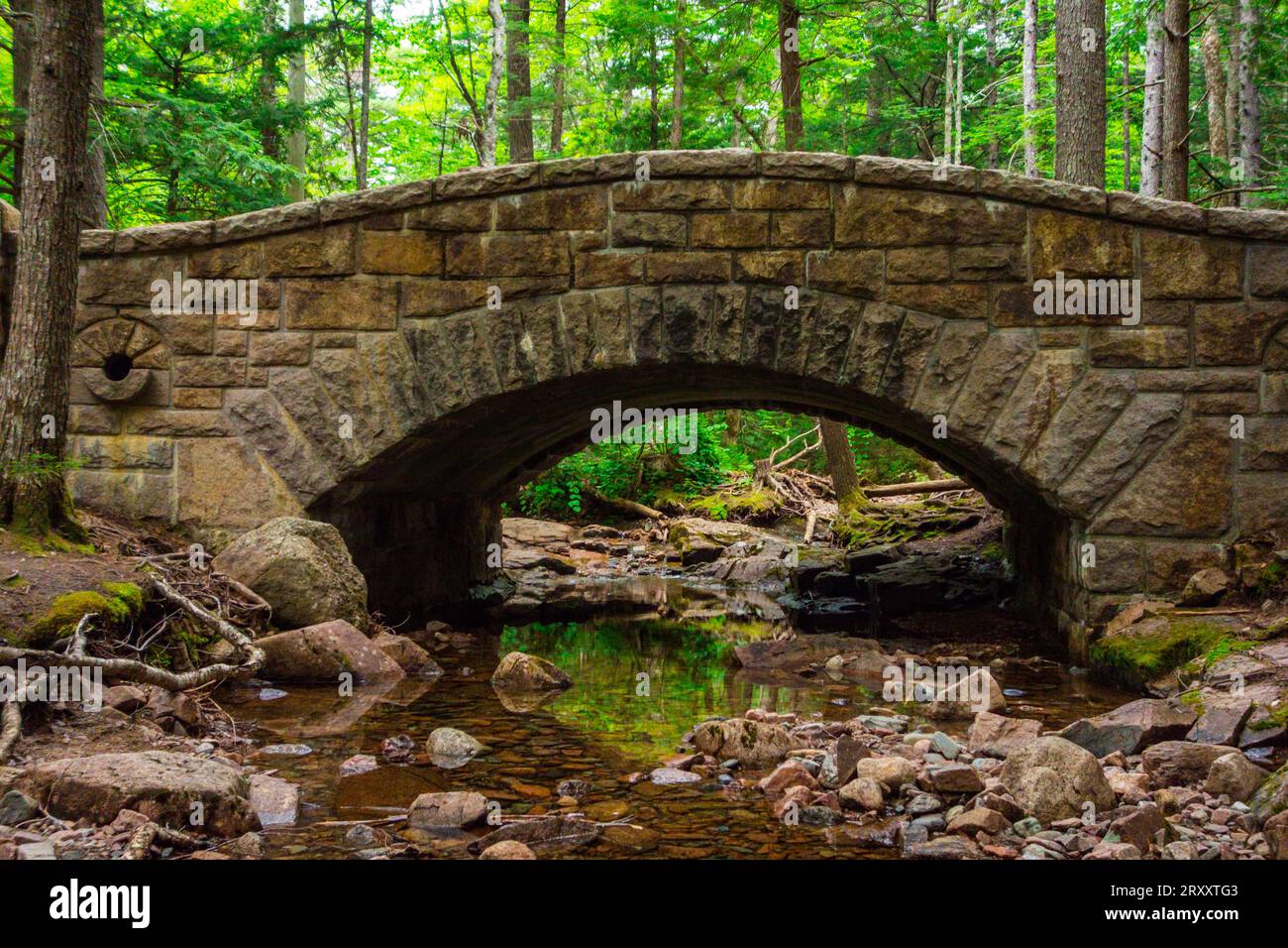 A stone arched bridge in the forest over a creek on the carriage trails ...