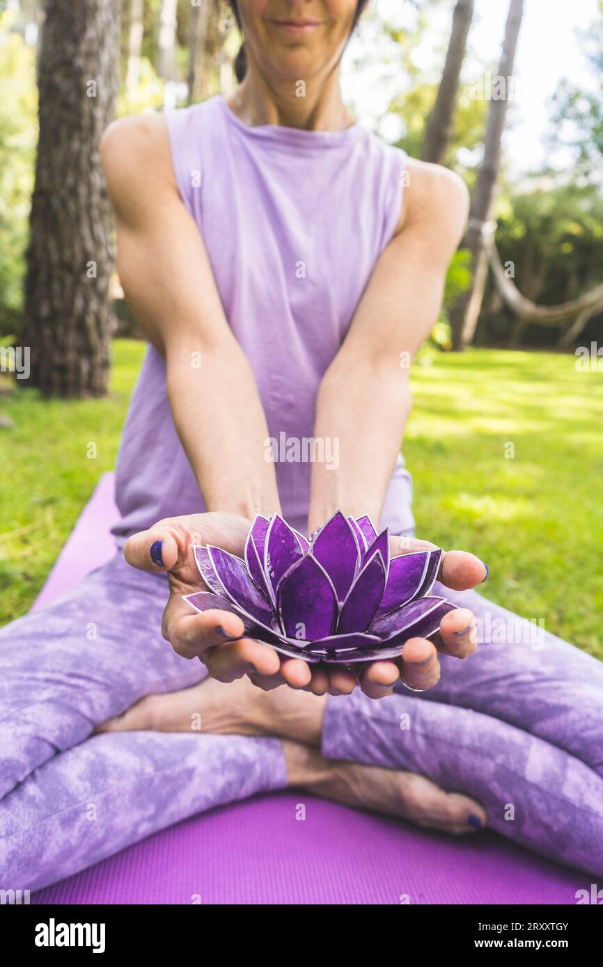 A woman offering a purple glass lotus. Yoga and meditation concept ...