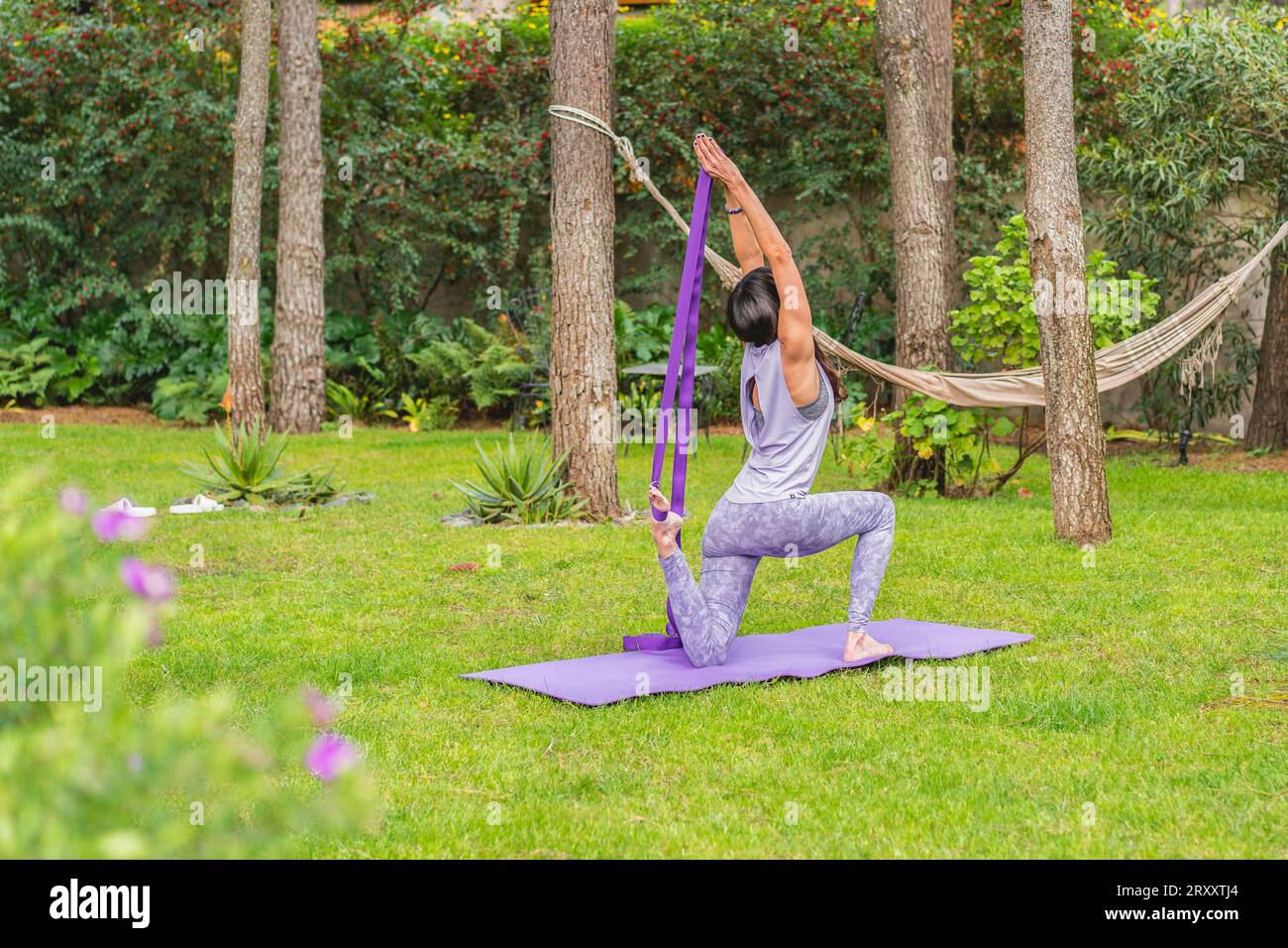 Back view of a woman exercising yoga with strap. Copy space Stock Photo ...