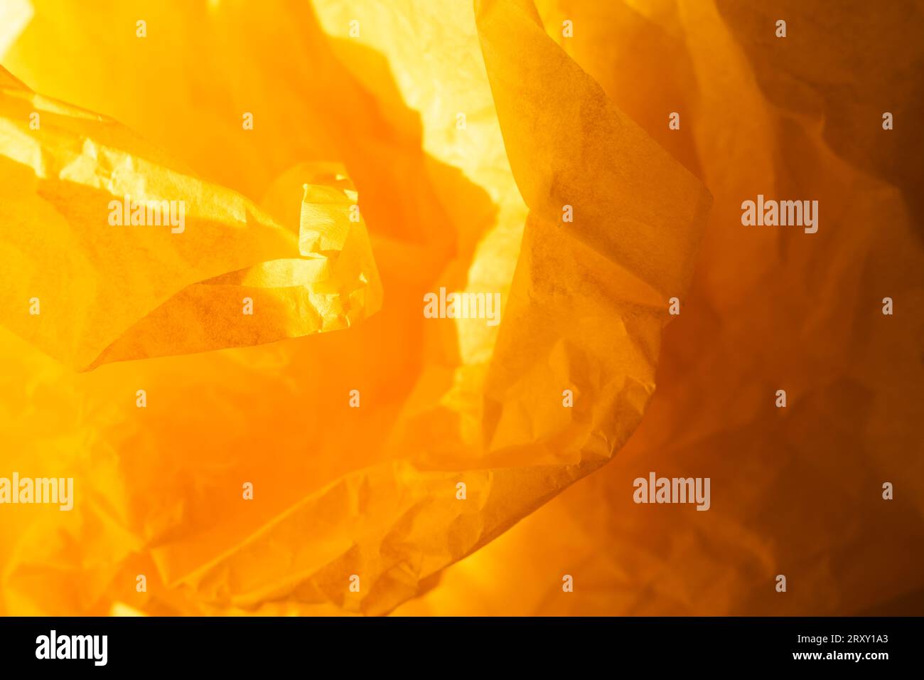 Wrinkled yellow paper with backlit illumination, shallow depth of field ...