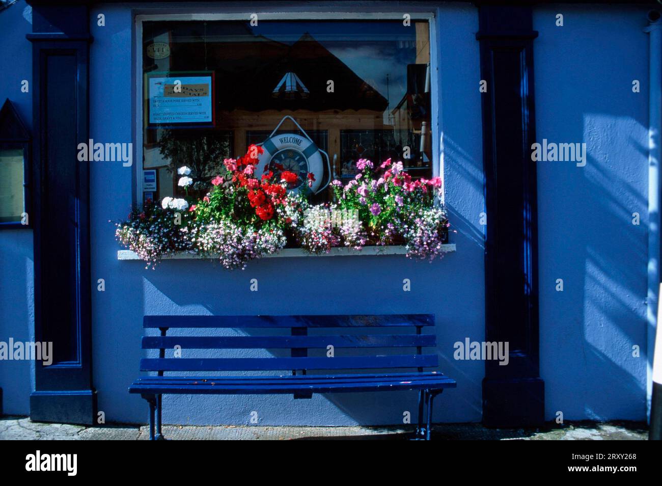 Window with floral decoration and bench of the pub in the Octagon ...