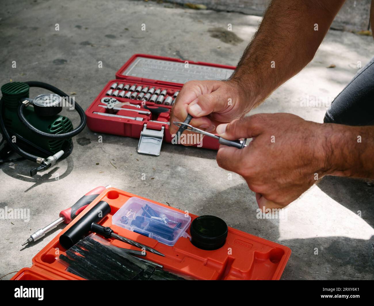 Concept: automobile mechanics. Hands with puncture repair tool kit ...
