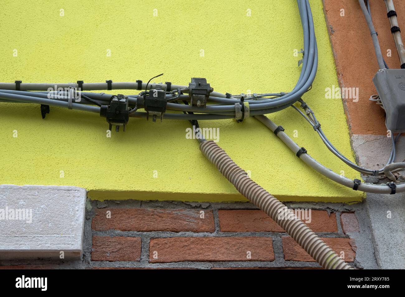 rudimentary electrical wiring on the outside of a building Stock Photo ...