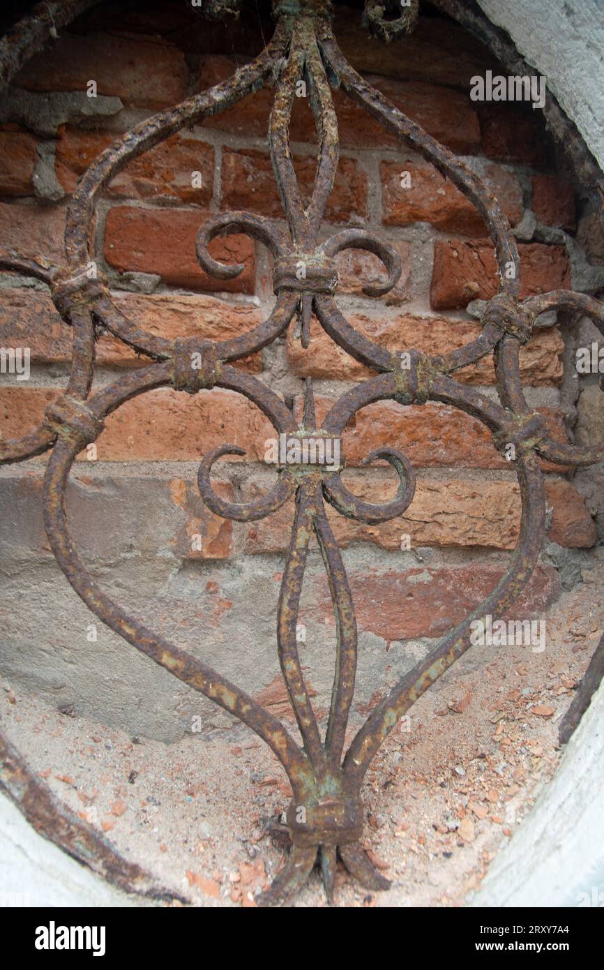 A rusted wrought iron grate over a bricked up round window Stock Photo ...