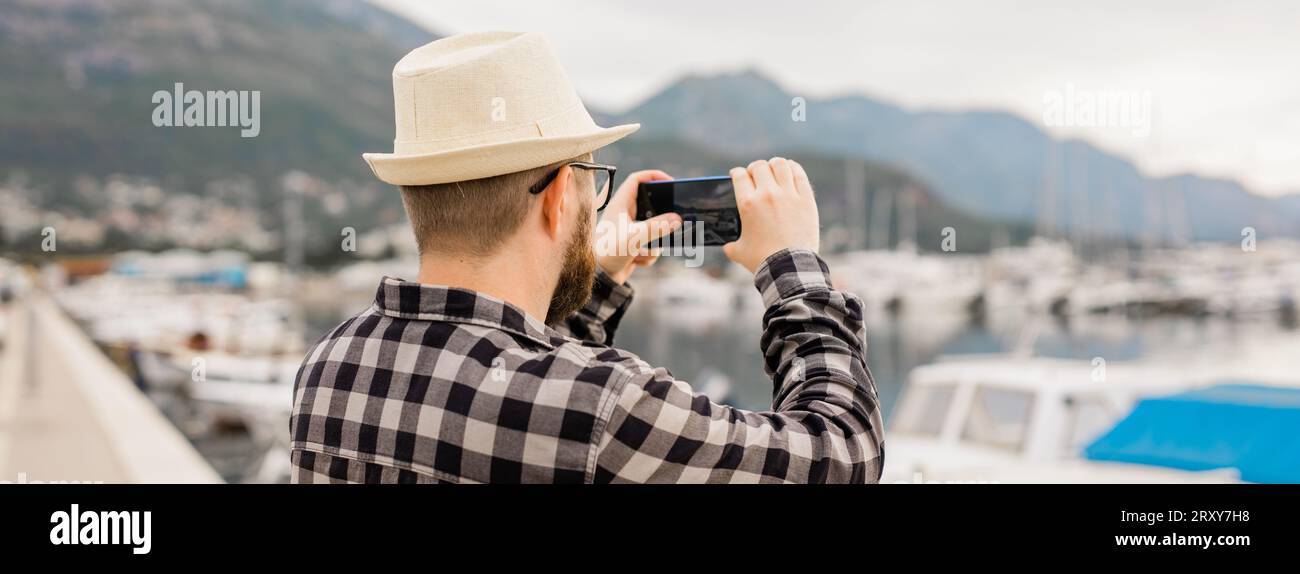 Traveller millennial man taking pictures of luxury yachts marine during ...