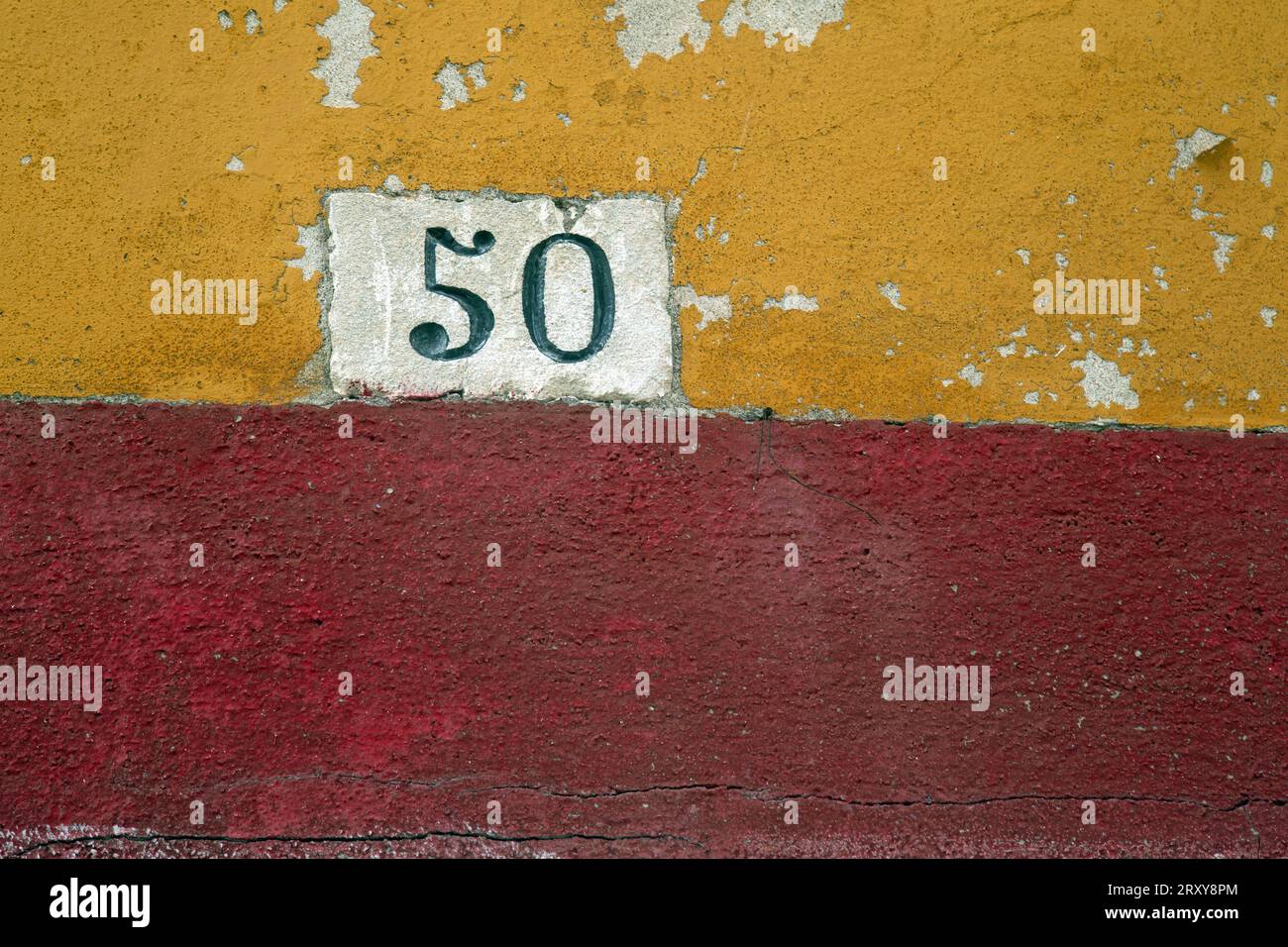 Number 50 on a brightly p[ainted wall, shot close up in landscape ...