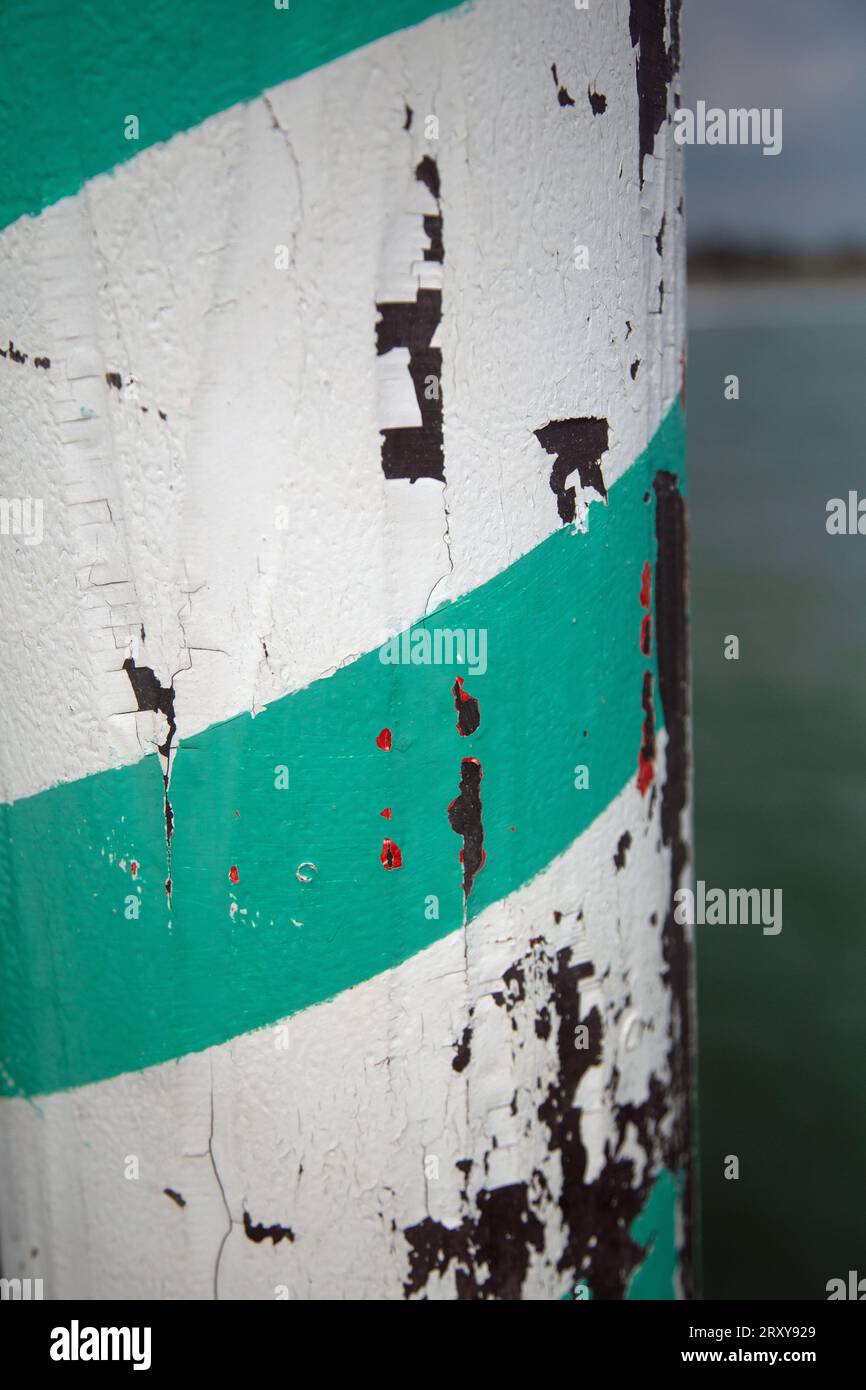 Green and white painted pole with a green spiral of paint running down ...