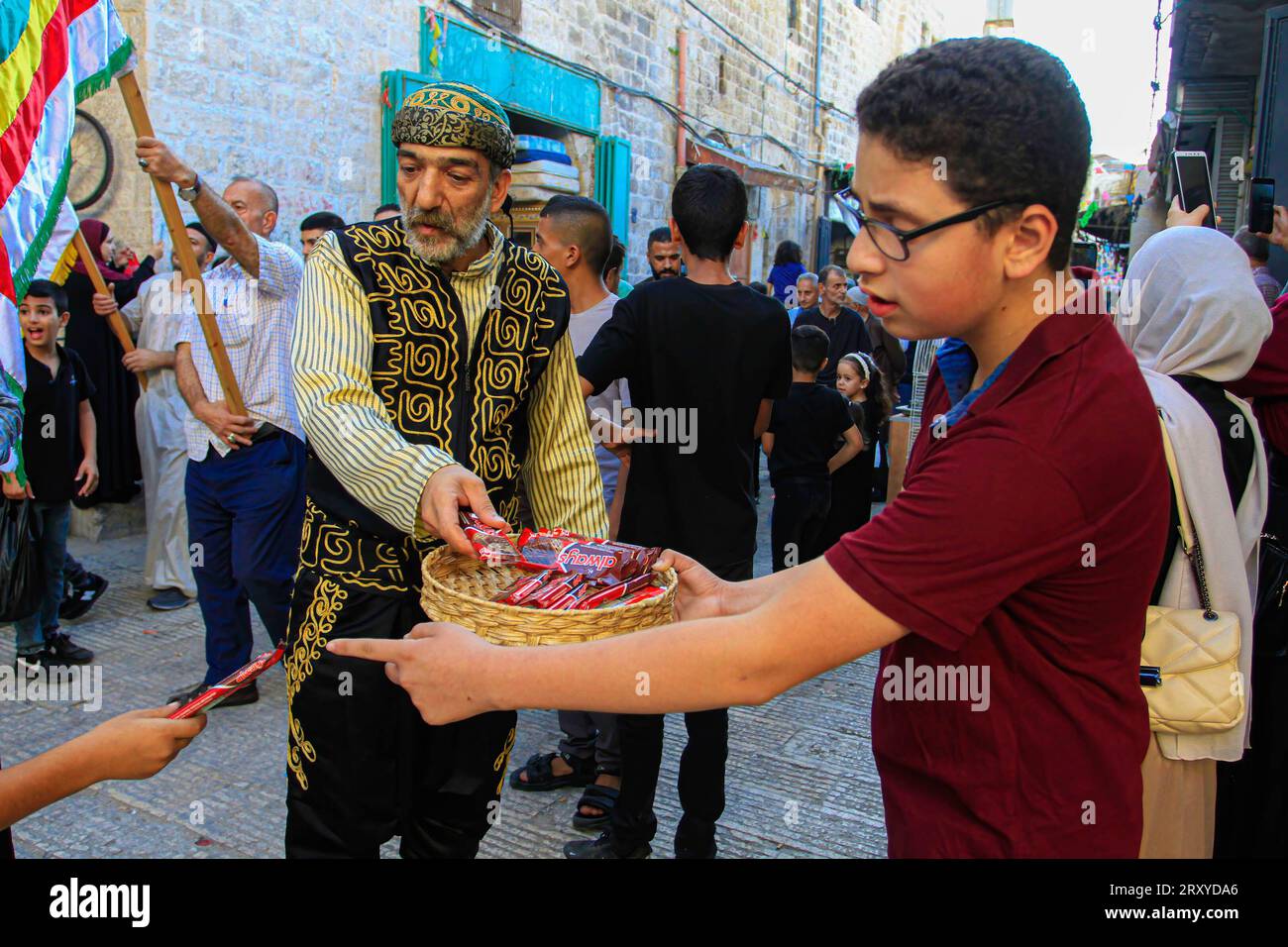 Palestinians distribute sweets to people during the celebration of the ...