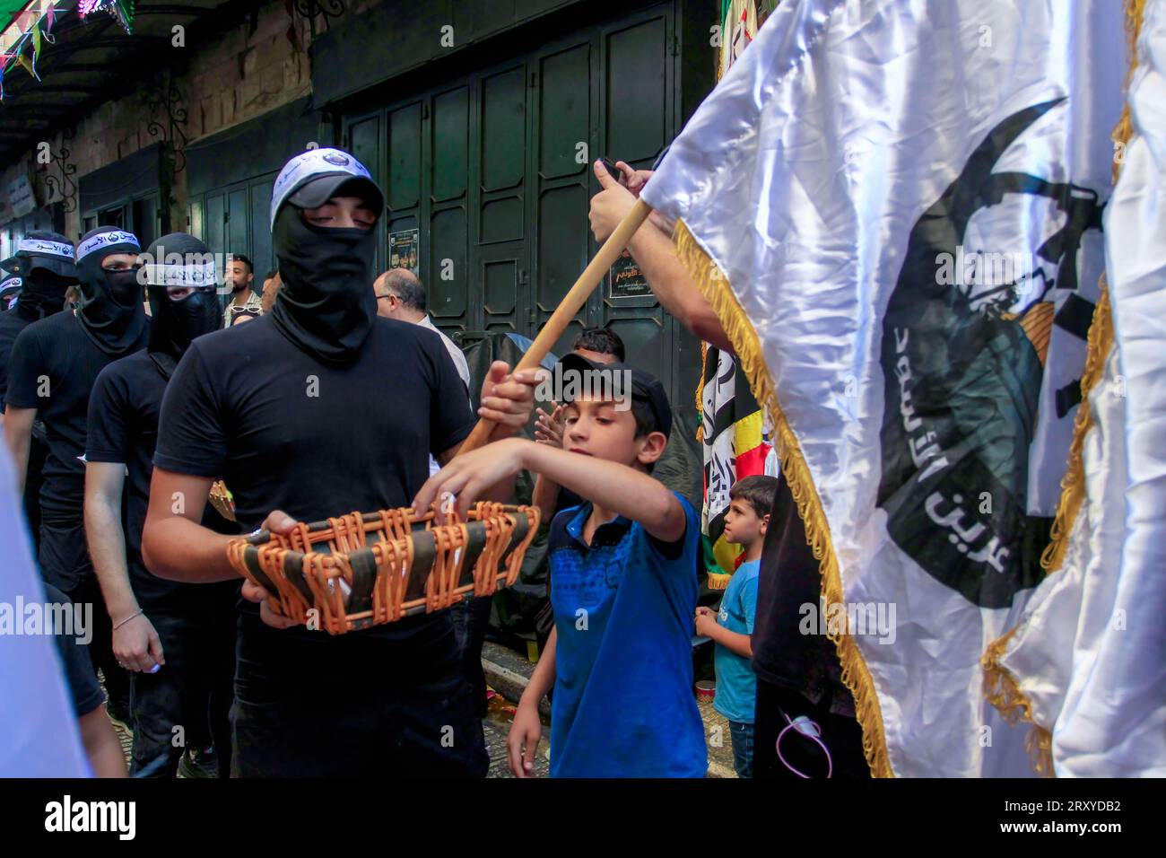 Palestinian members of the Lions' Den group distribute sweets to people ...