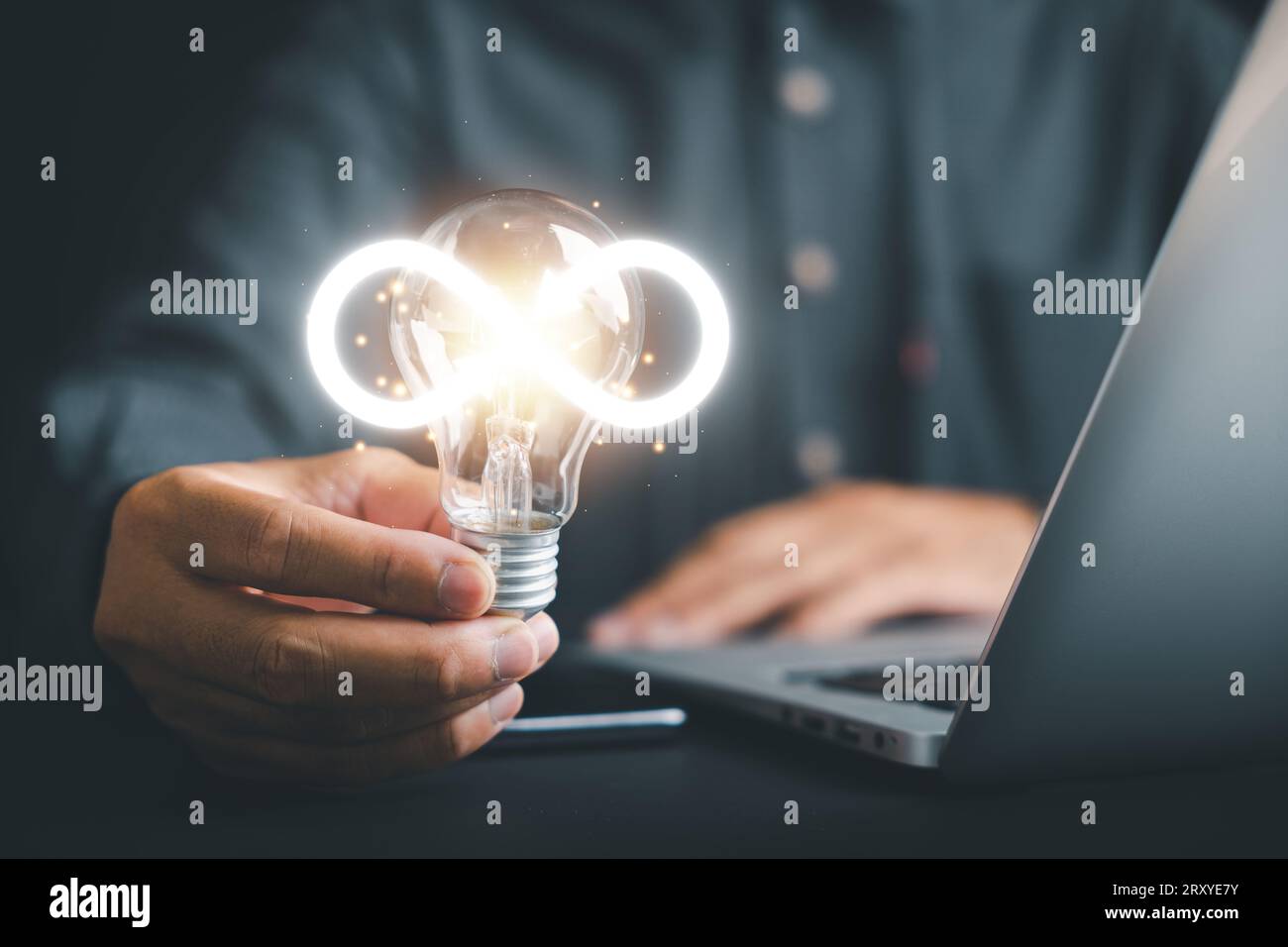 Man emphasizes light bulb with infinite symbol icon Stock Photo - Alamy