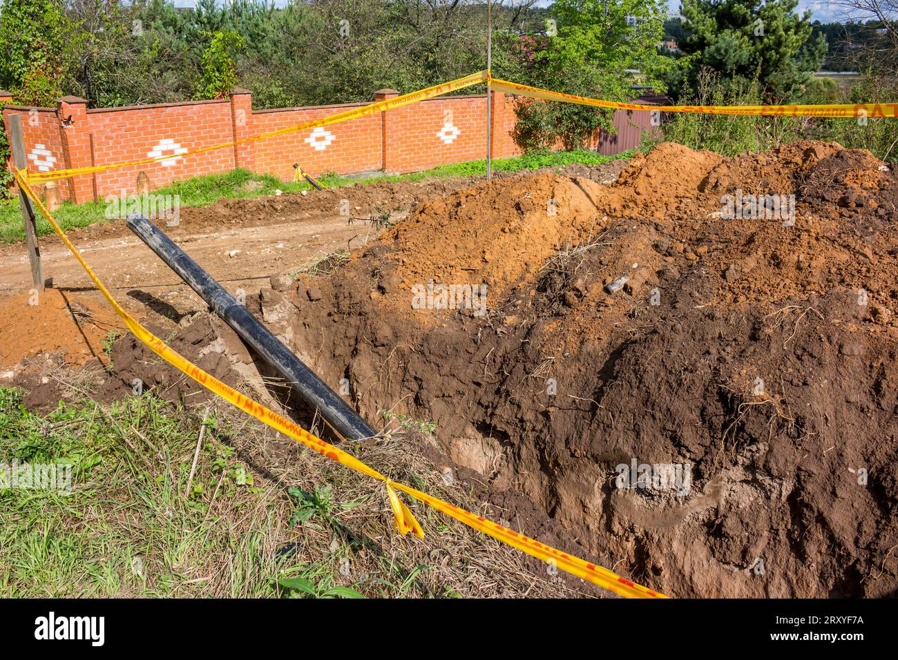 Gas supply in a populated area. Laying plastic pipes in a dug trench ...