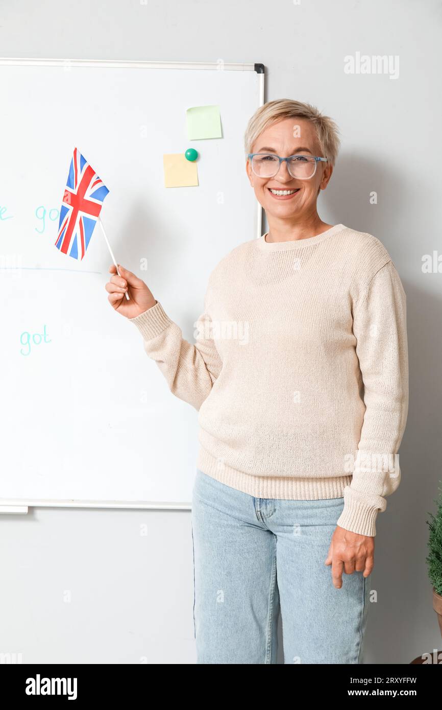 Female English teacher with UK flag in classroom Stock Photo - Alamy