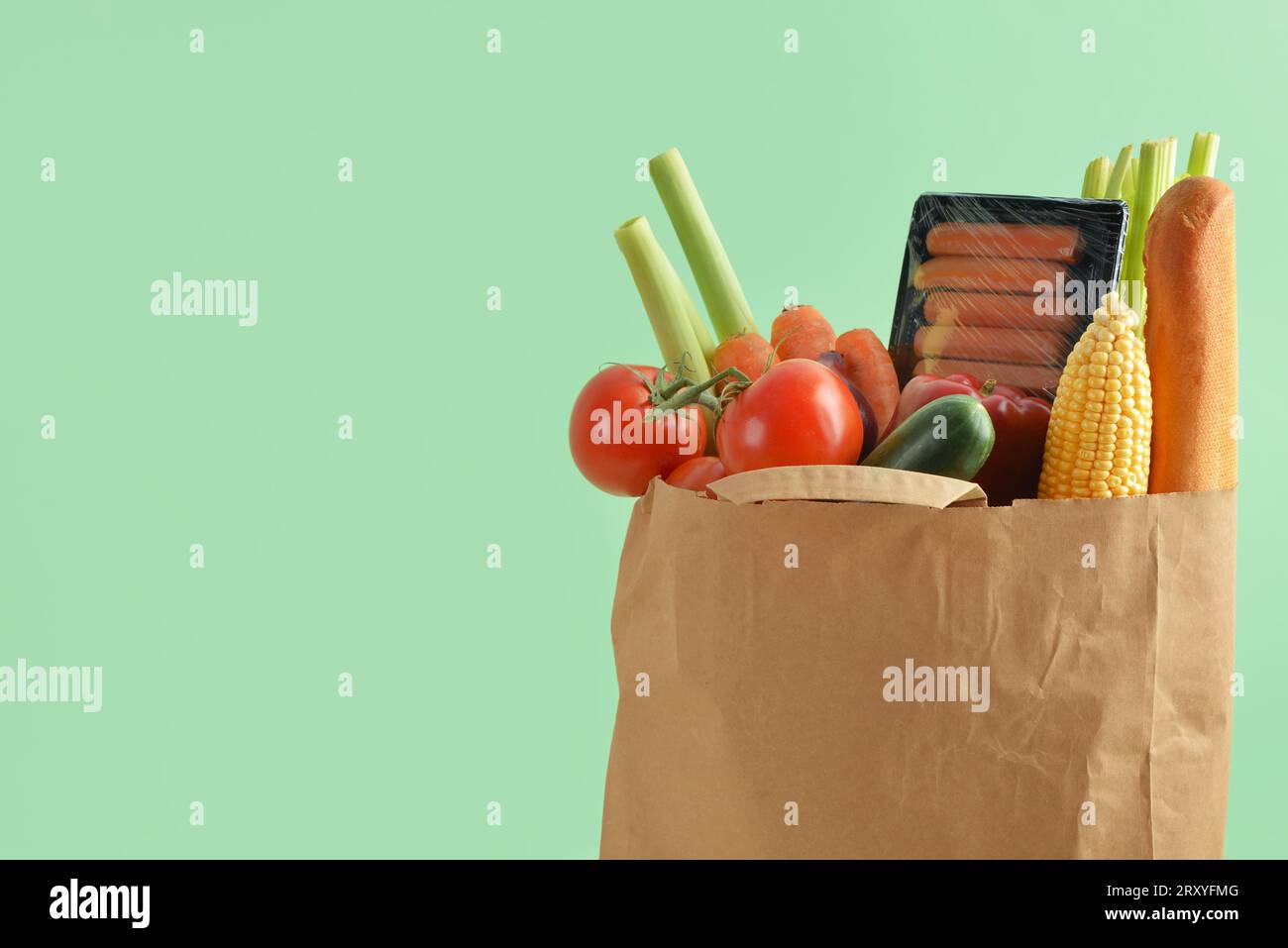 Paper bag with food on green background. Grocery shopping concept Stock ...