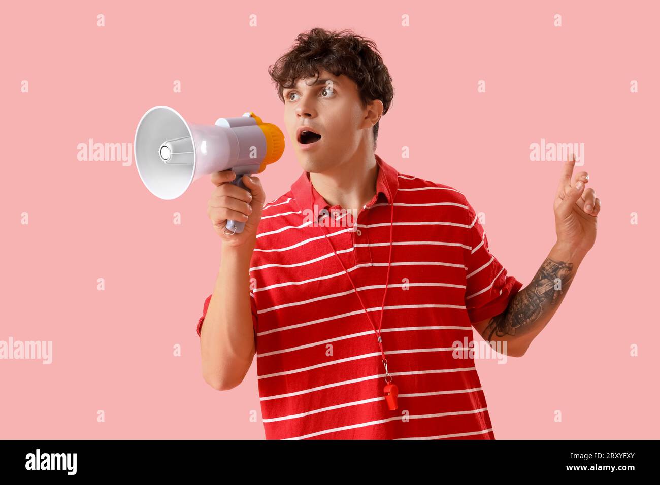 Male lifeguard shouting into megaphone on pink background Stock Photo ...