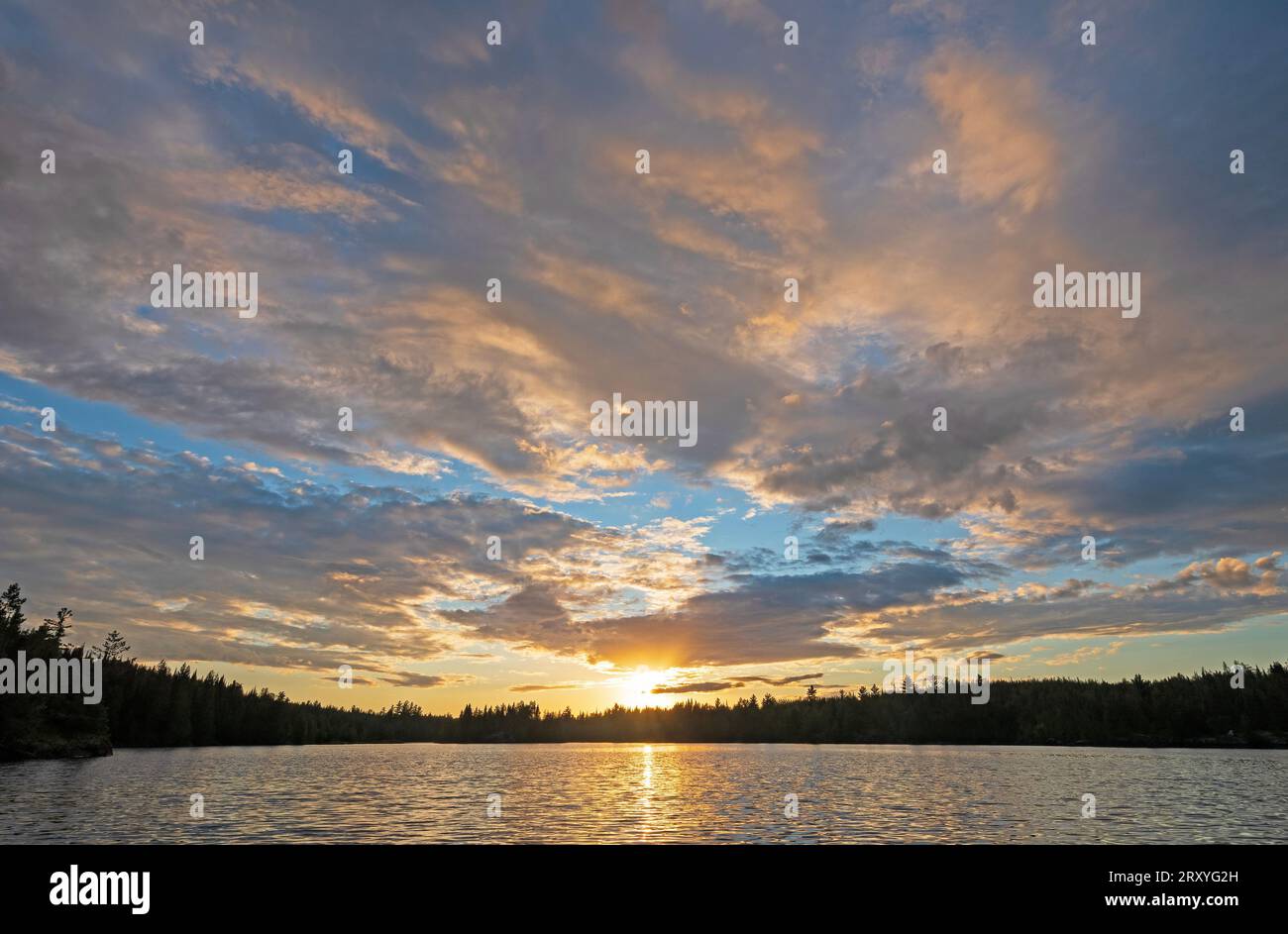 The Sun Setting Amidst High Clouds on Jenny Lake in the Boundary Waters ...