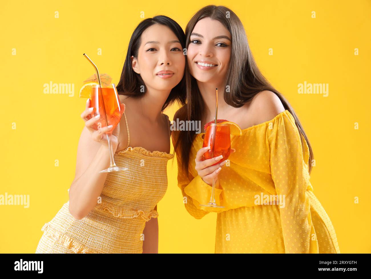 Beautiful young women with glasses of tasty aperol spritz cocktail on ...