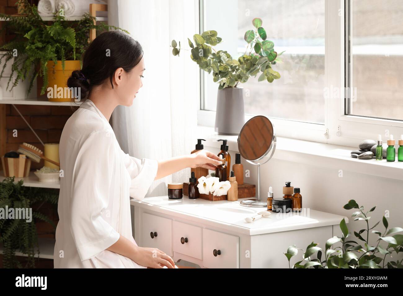 Beautiful Asian woman at dressing table in bathroom Stock Photo - Alamy