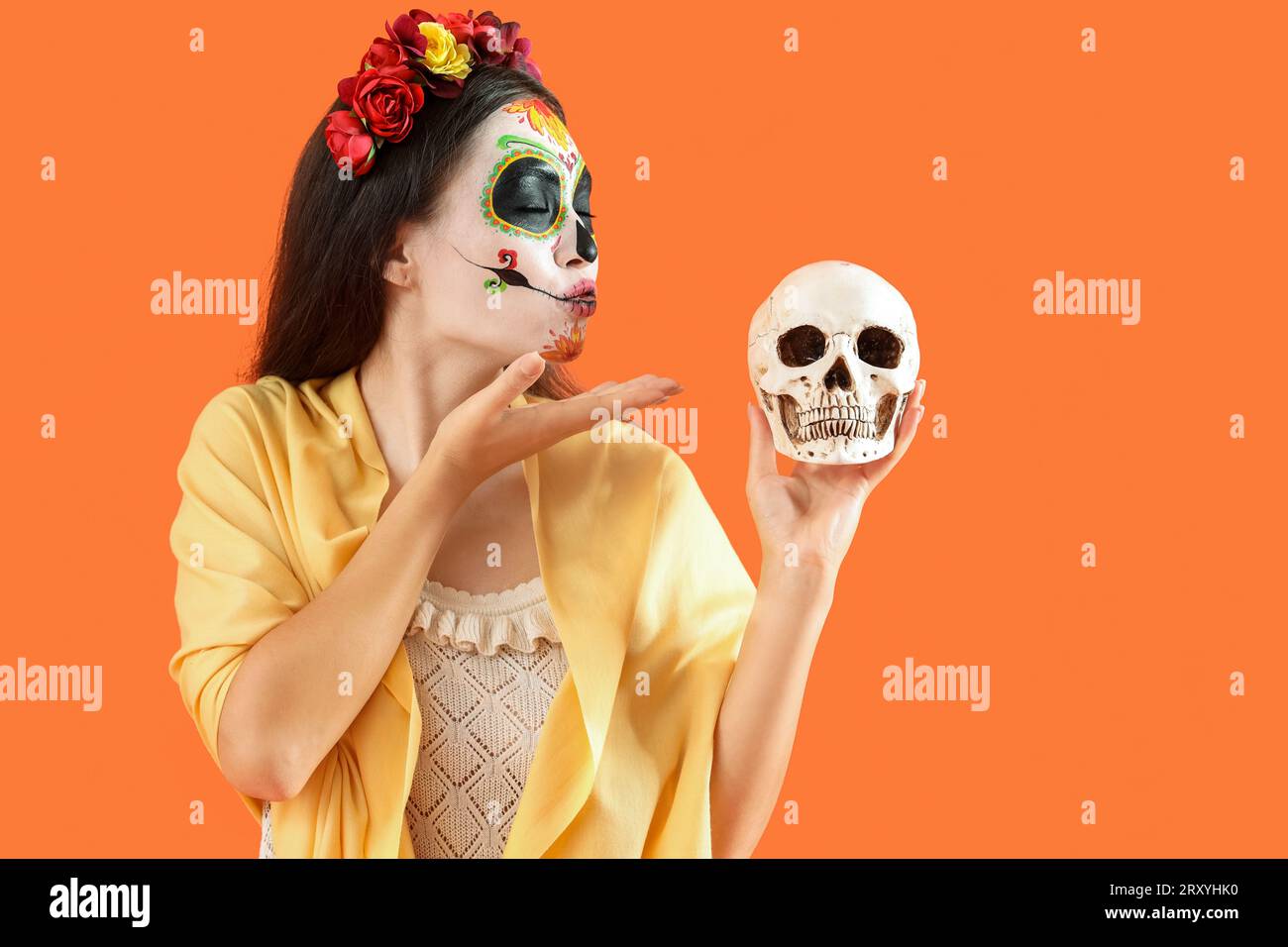 Beautiful woman dressed for Halloween with painted skull blowing kiss ...
