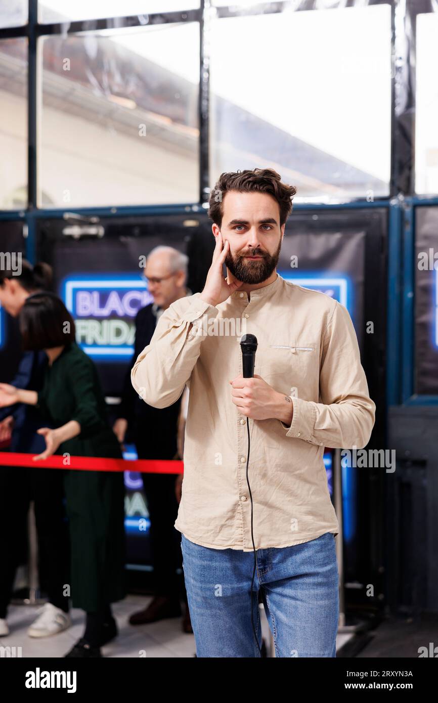 Professional TV news reporter standing with microphone against lined up ...
