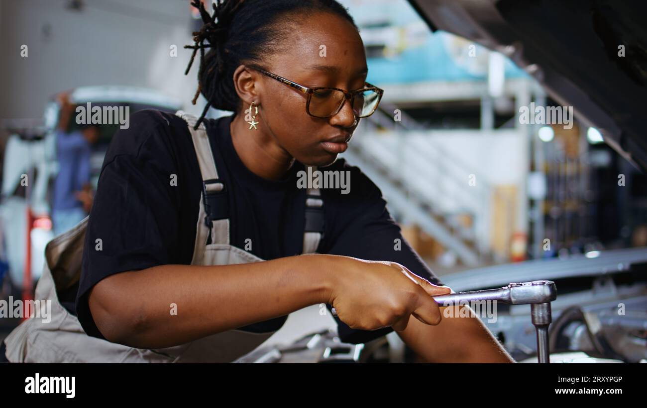 Certified technician in repair shop using torque wrench to tighten ...