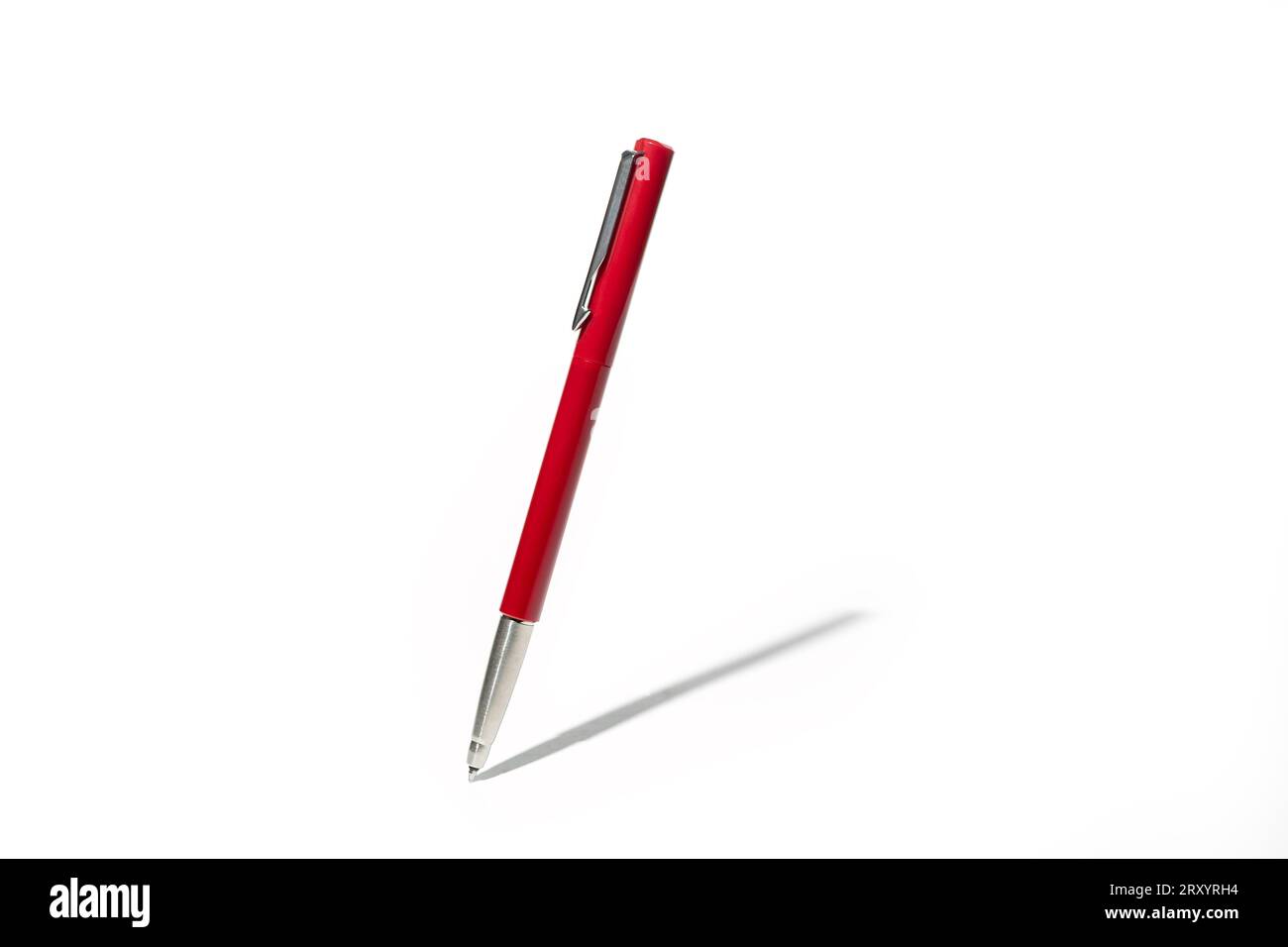 Detailed red classic ballpoint pen writing on white surface with its ...