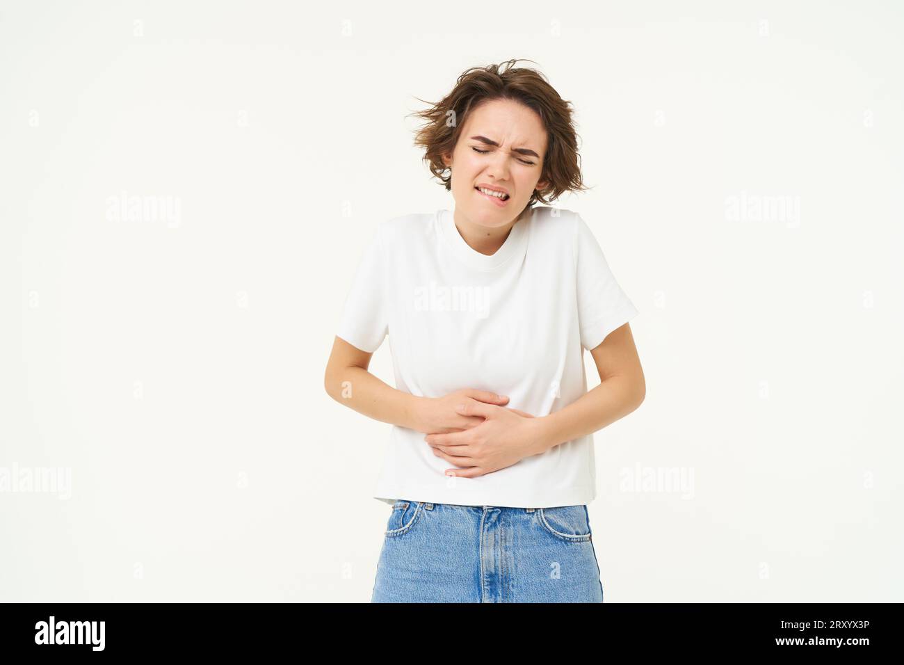 Image of woman with stomach ache, touching her belly, grimacing from ...