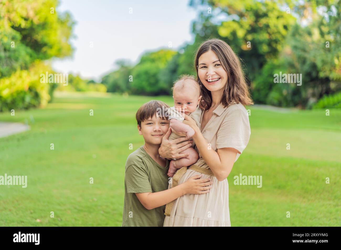 A happy 40-year-old mother cradles her newborn with her adult son in a ...