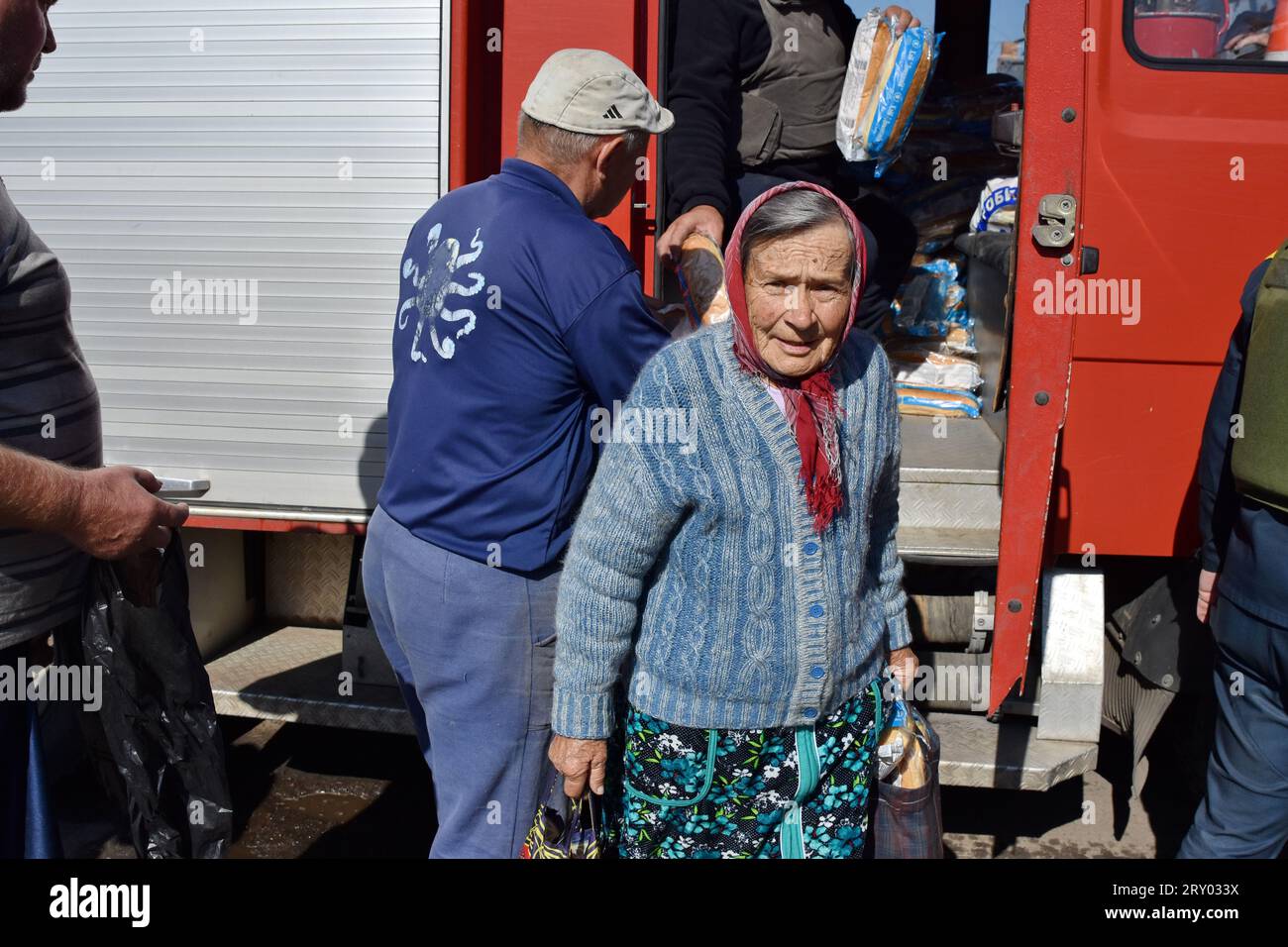 People receive loaves of bread at a humanitarian aid distribution spot ...