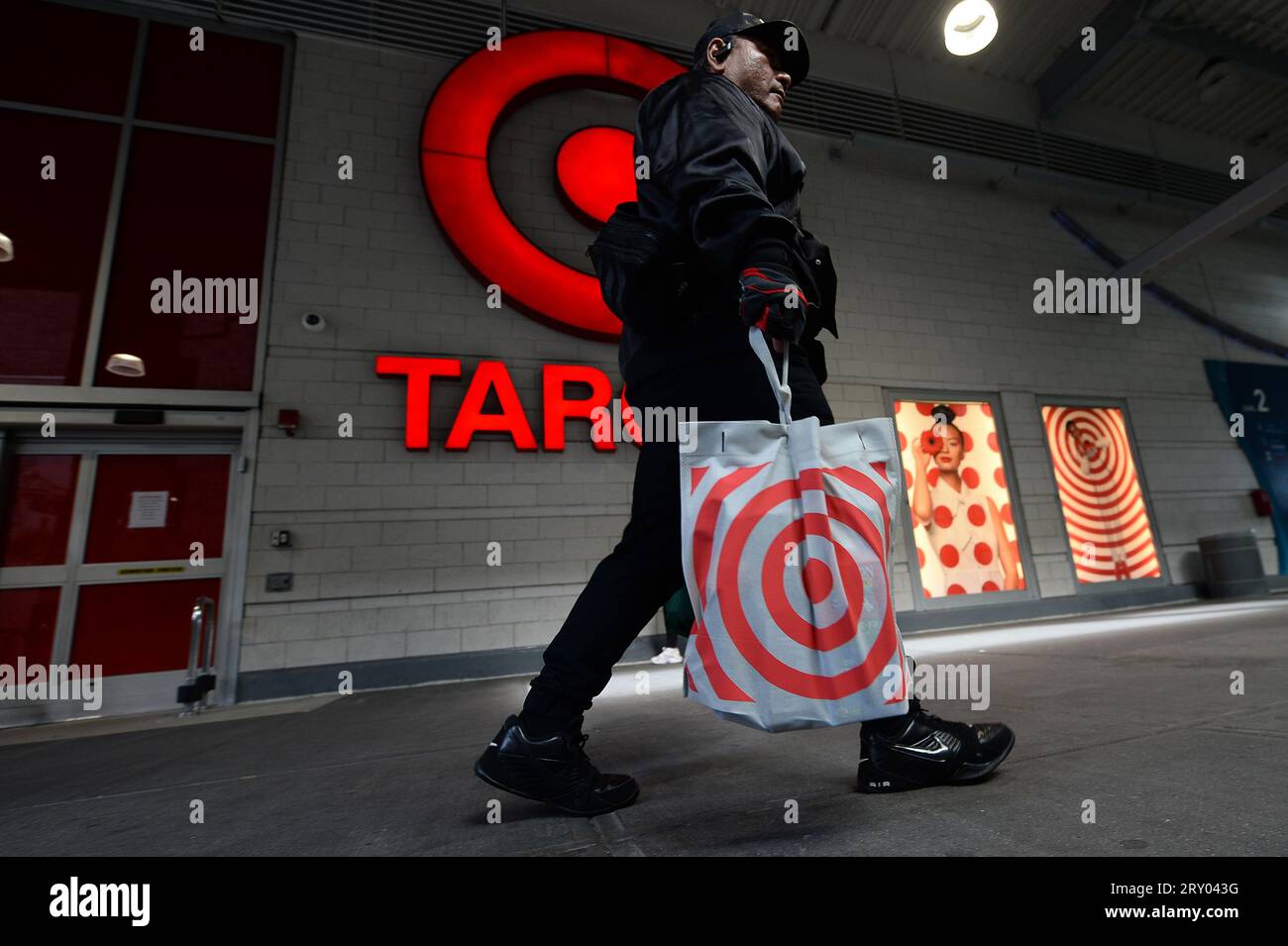 A shopper walks past the Target store logo affixed to the Harlem ...