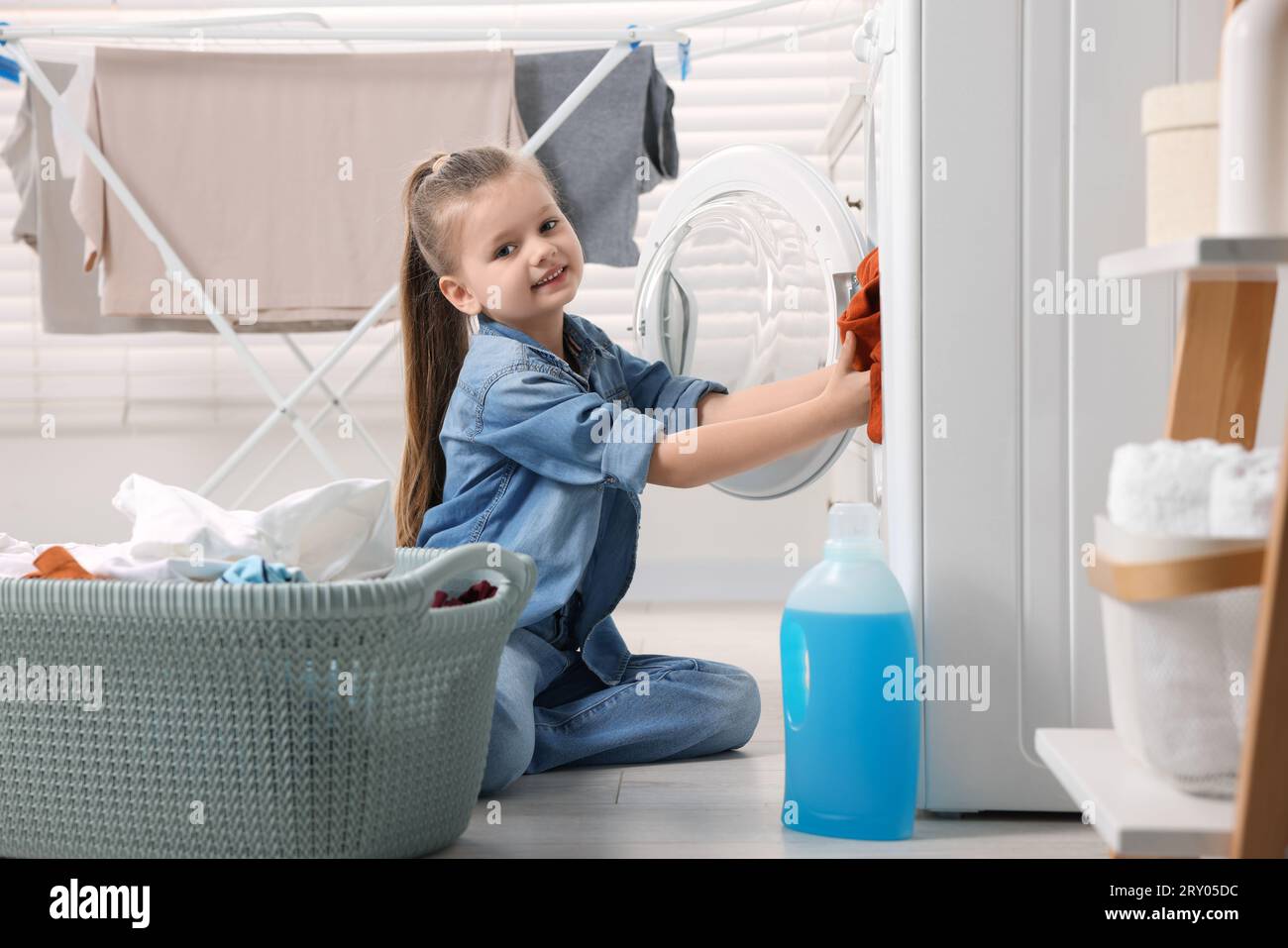 Child putting clothes washing machine hi-res stock photography and ...