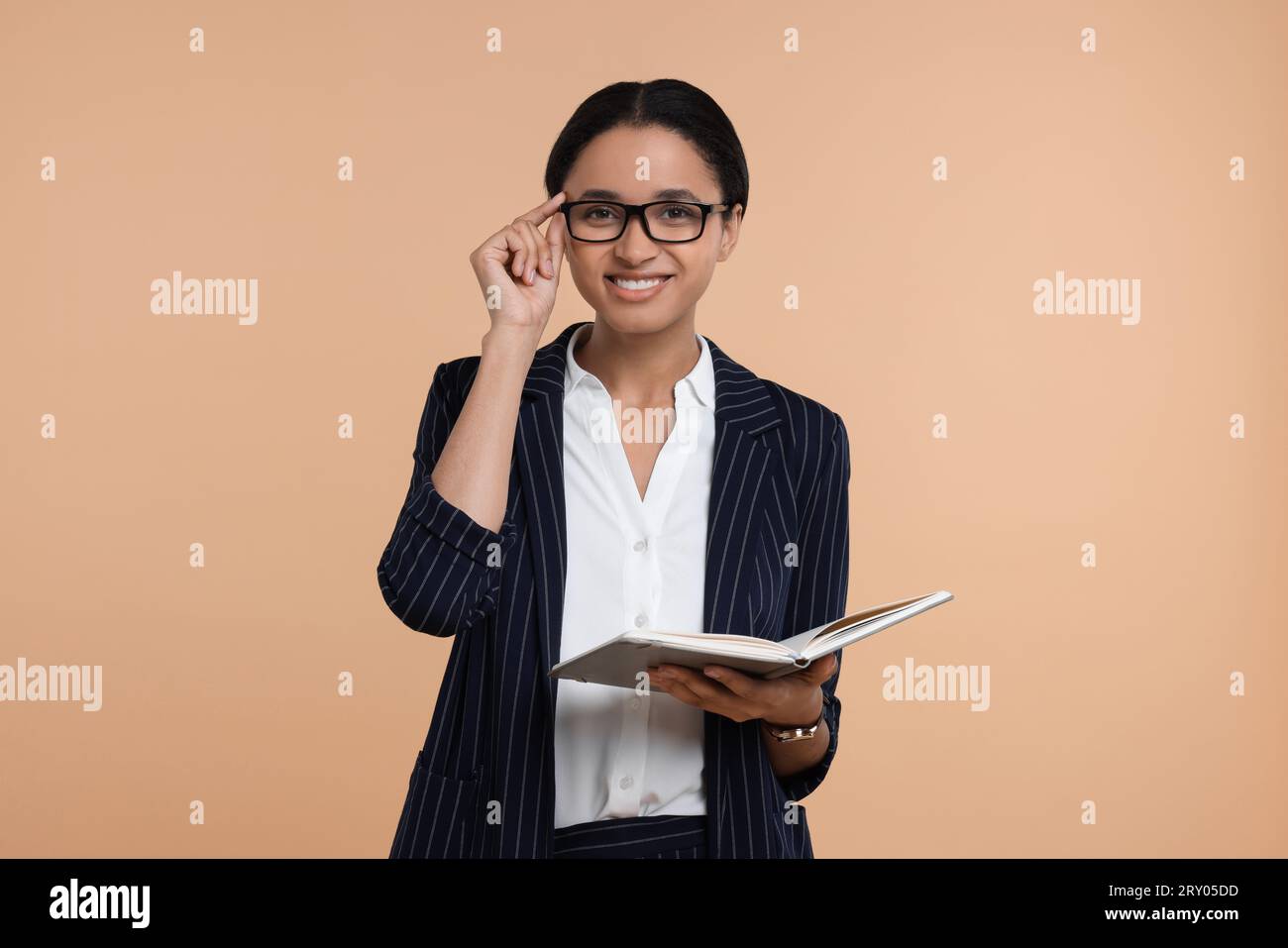 Beautiful secretary with notebook on beige background Stock Photo - Alamy